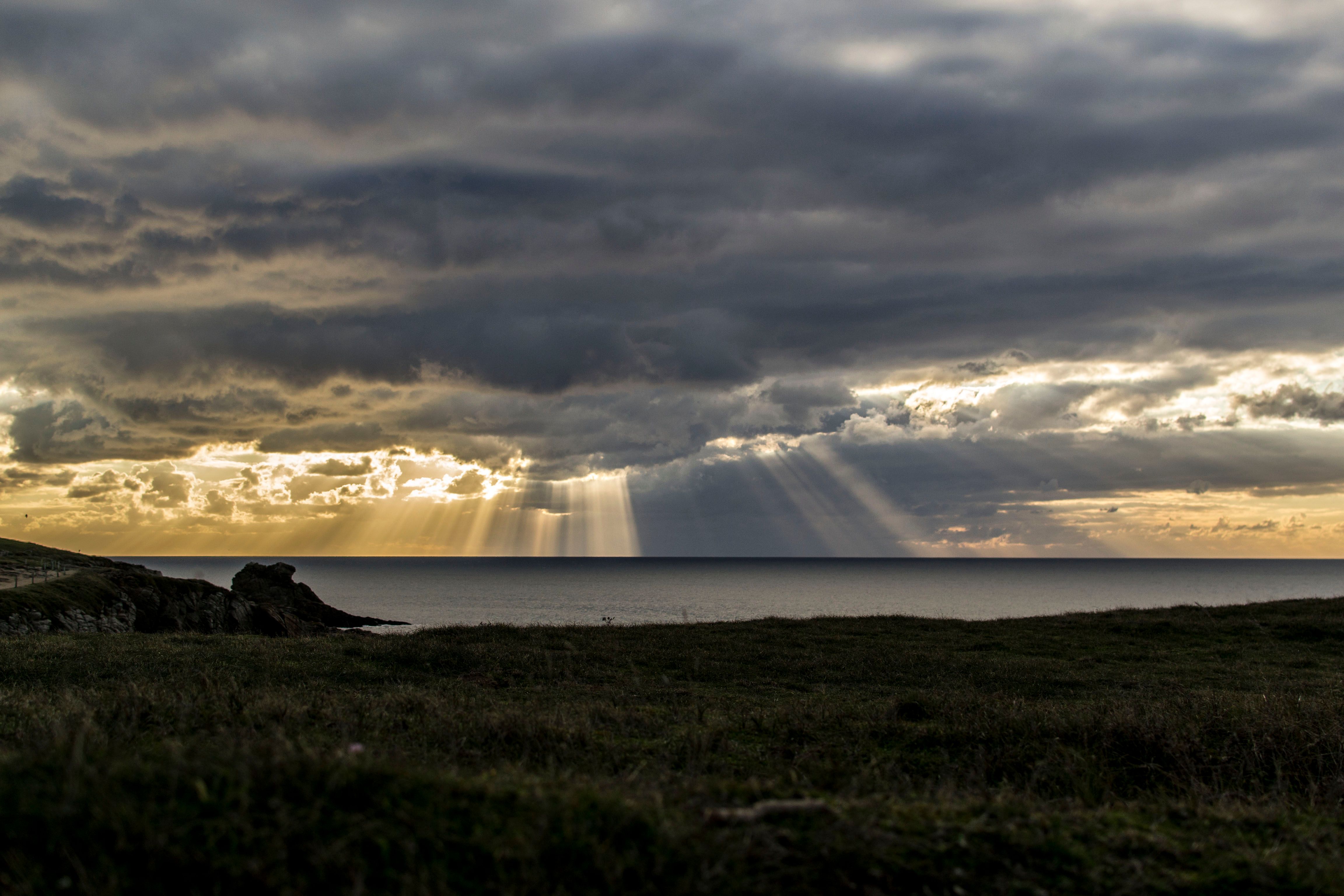 Sunlight over Lake near City at Sunset under Clouds · Free Stock Photo