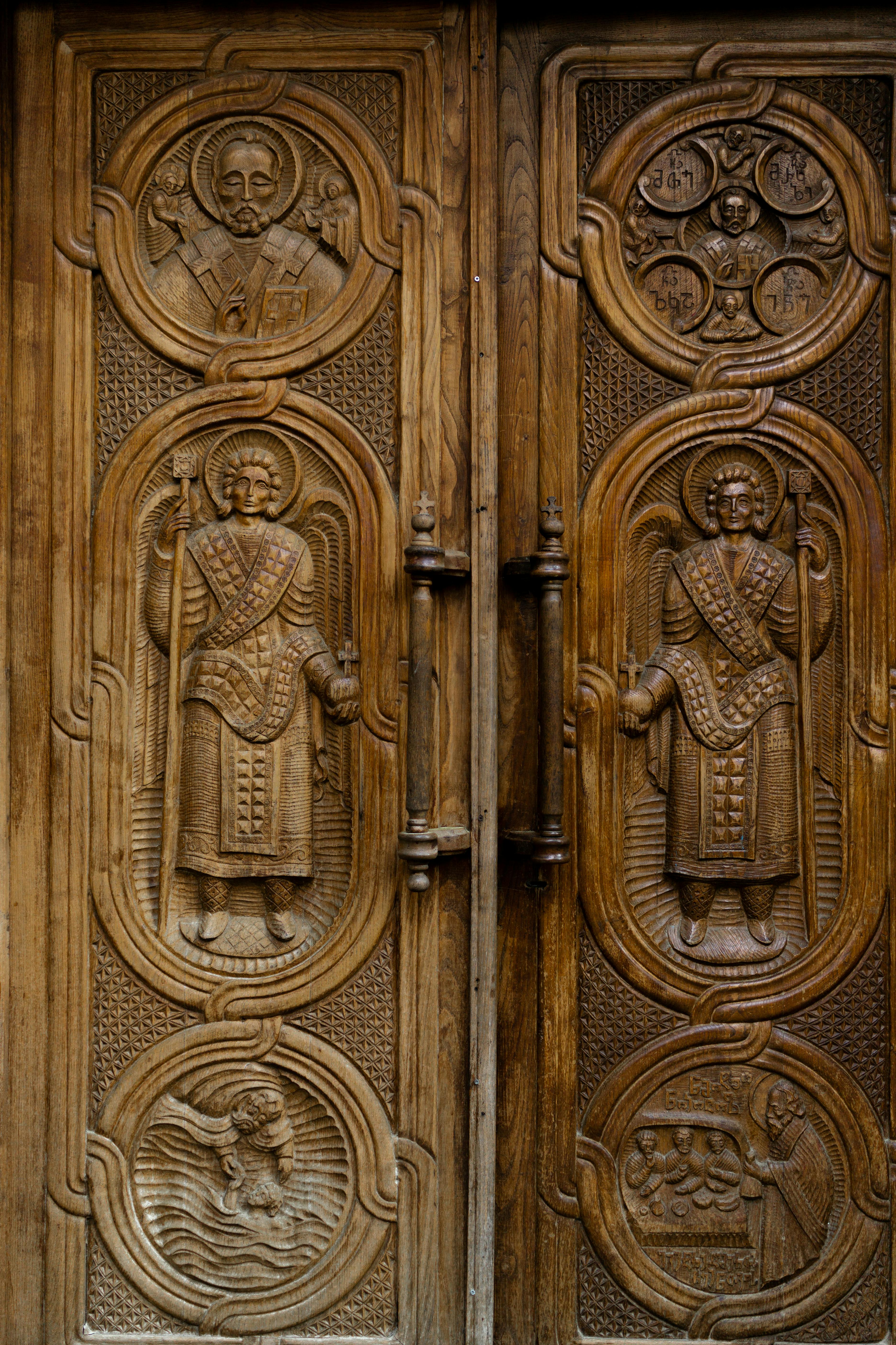 Ornate Wooden Door with Reliefs of Saints · Free Stock Photo