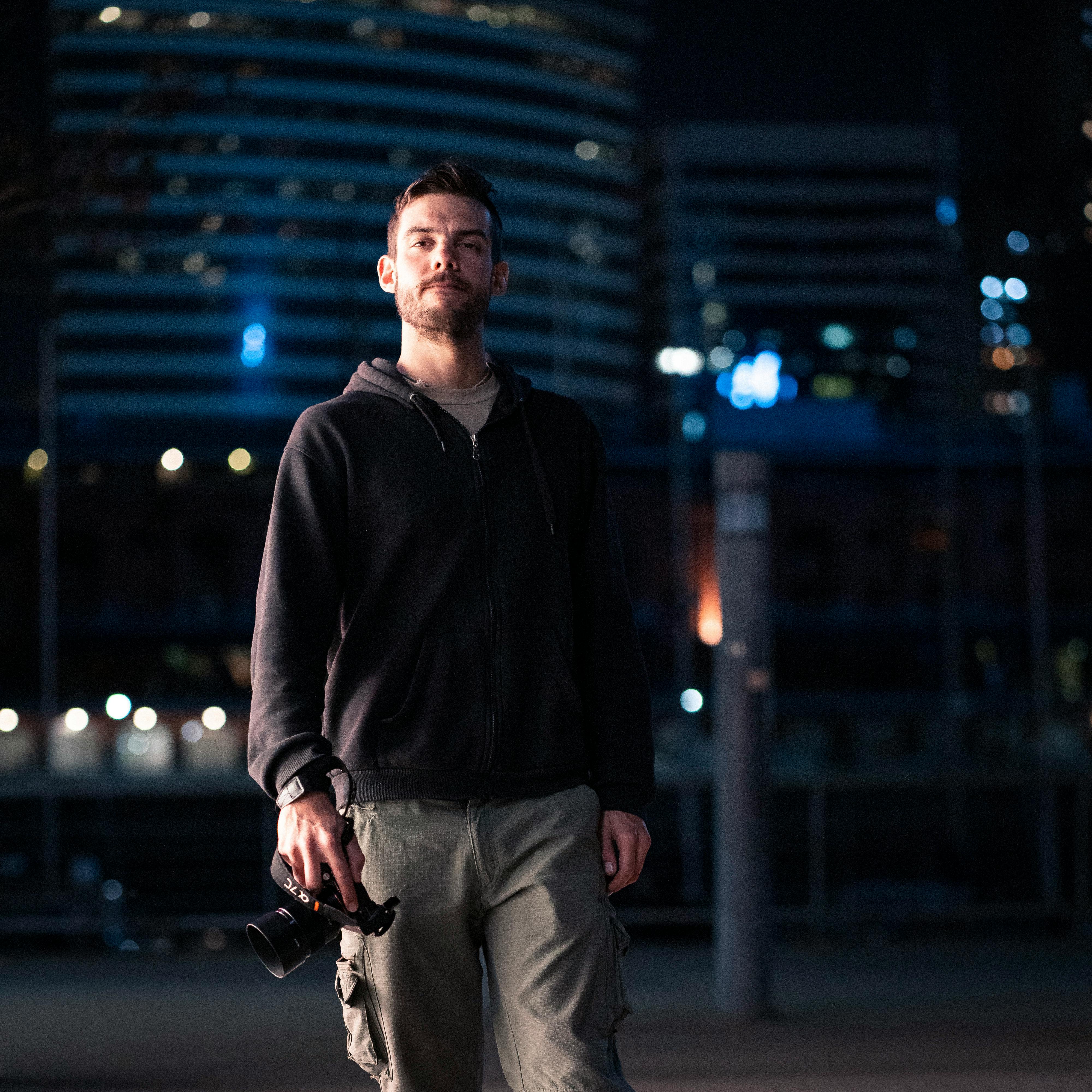 Man Holding a Camera Walking on the Street · Free Stock Photo