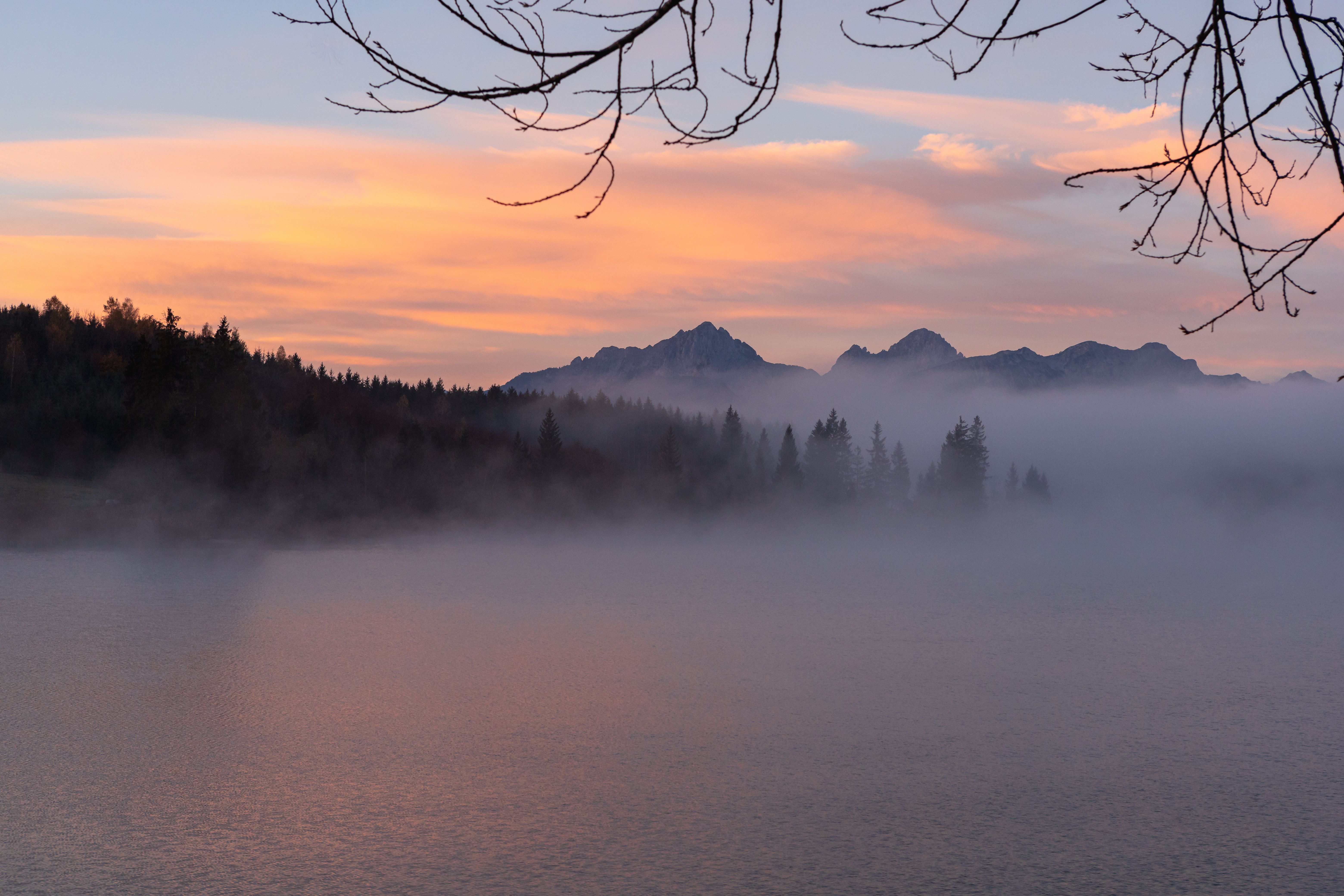 Fog over the Water and Mountains in Distance at Sunset · Free Stock Photo