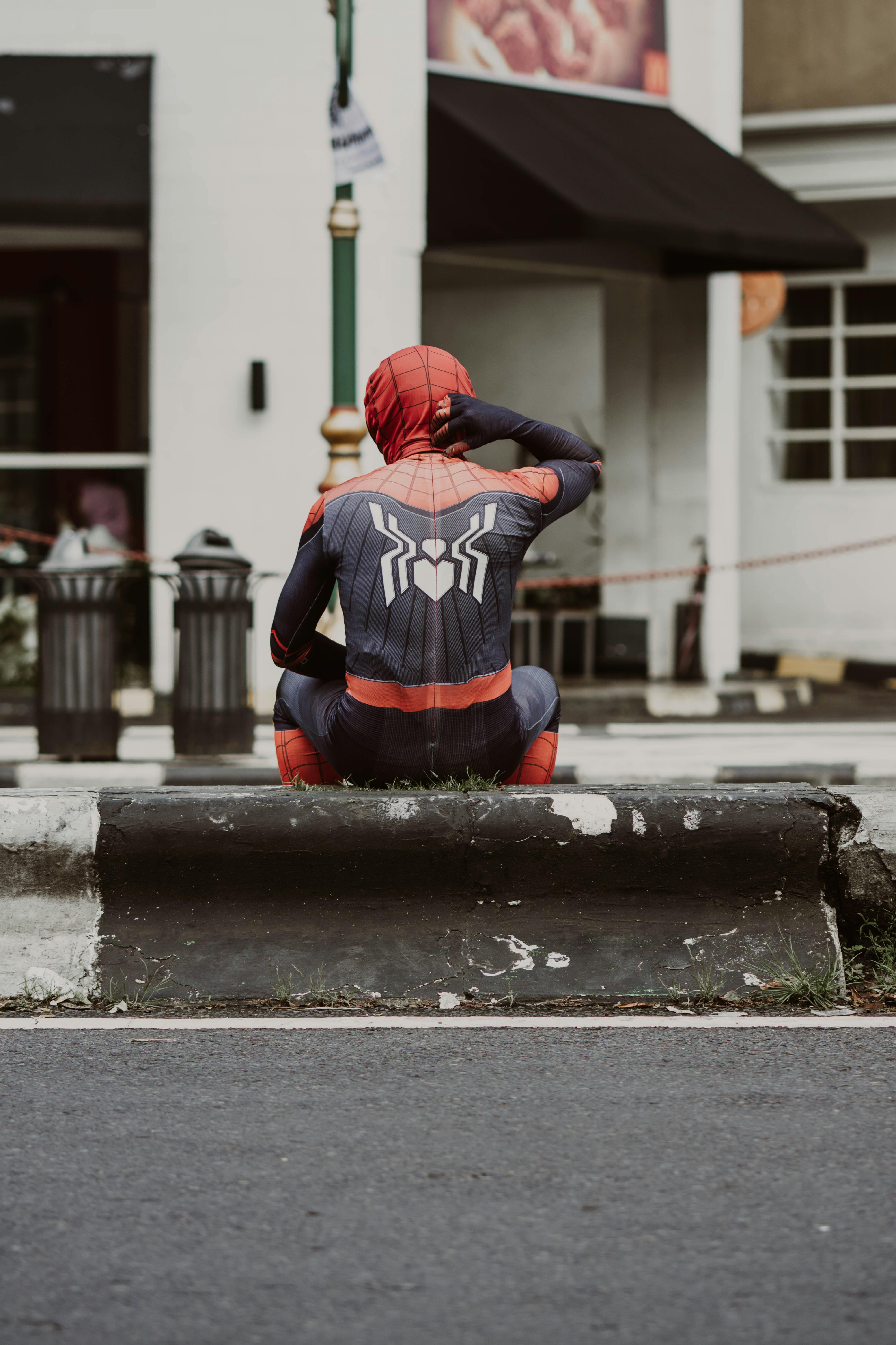 Spiderman Sitting on Wall near Street · Free Stock Photo