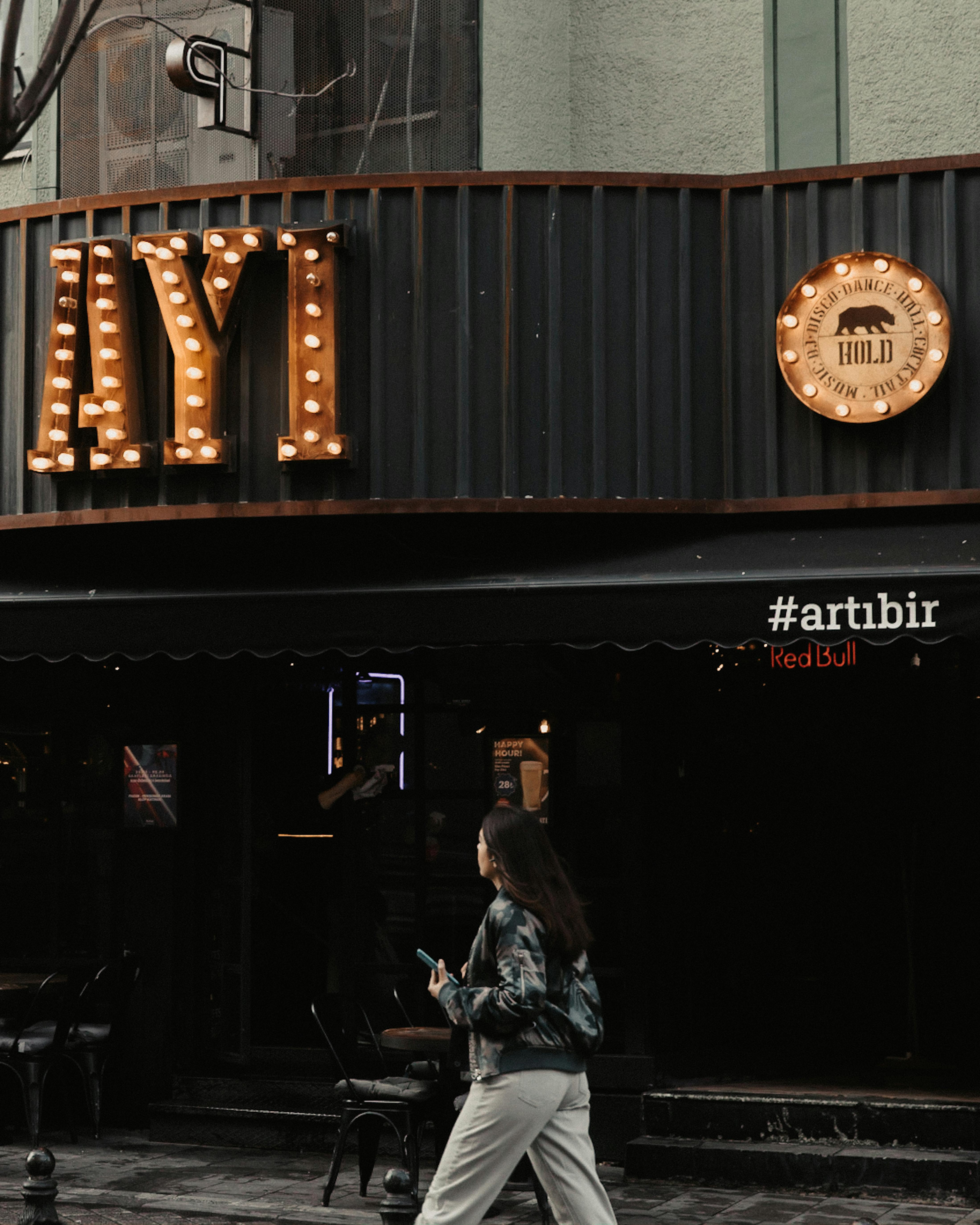 Woman Walking in front of a Bar in City · Free Stock Photo