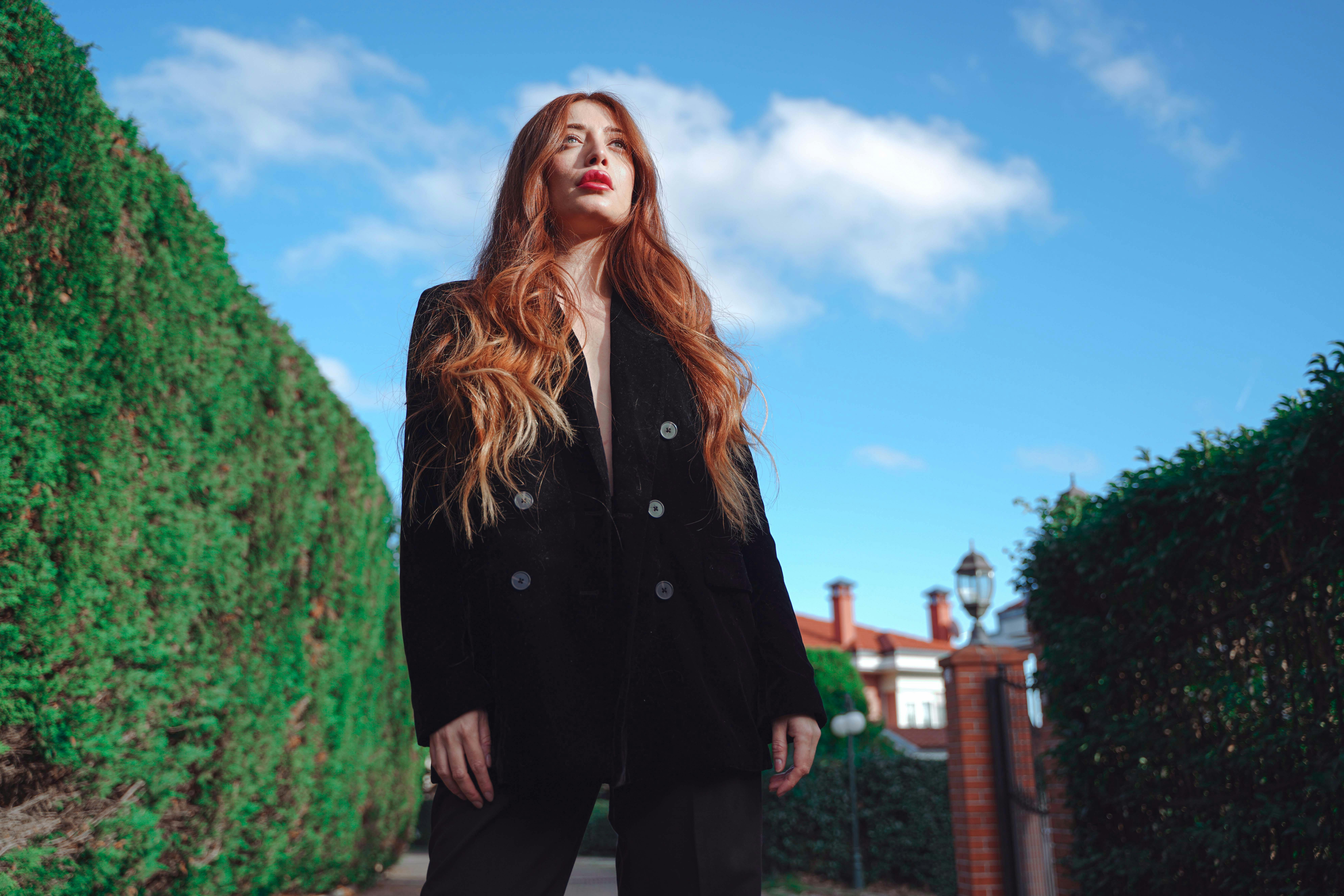Redhead Woman in Suit Posing in Garden · Free Stock Photo