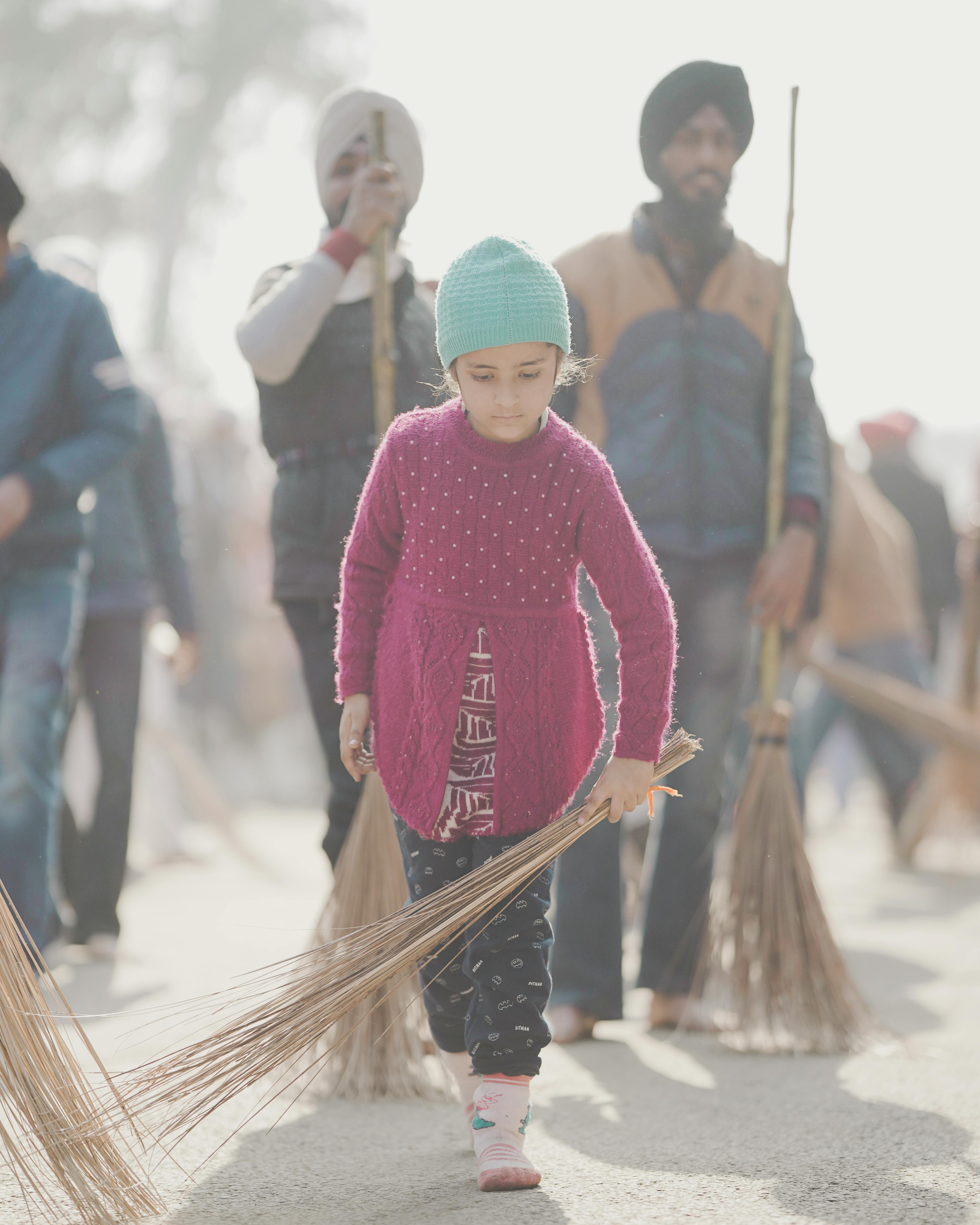 A Long Haired Man Holding a Broom · Free Stock Photo