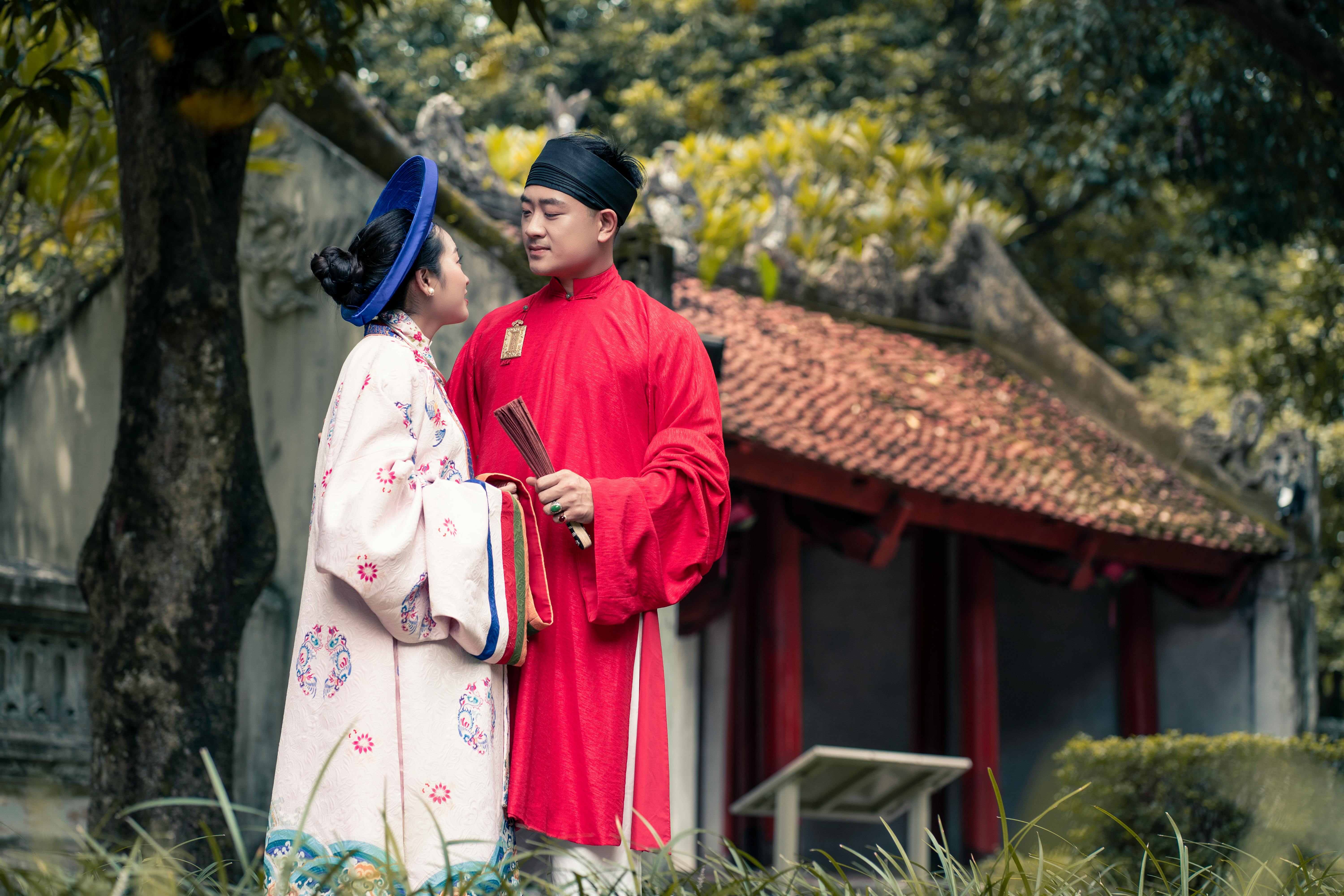 A Couple Wearing Hanfu Dress Standing Face to Face while Looking at ...