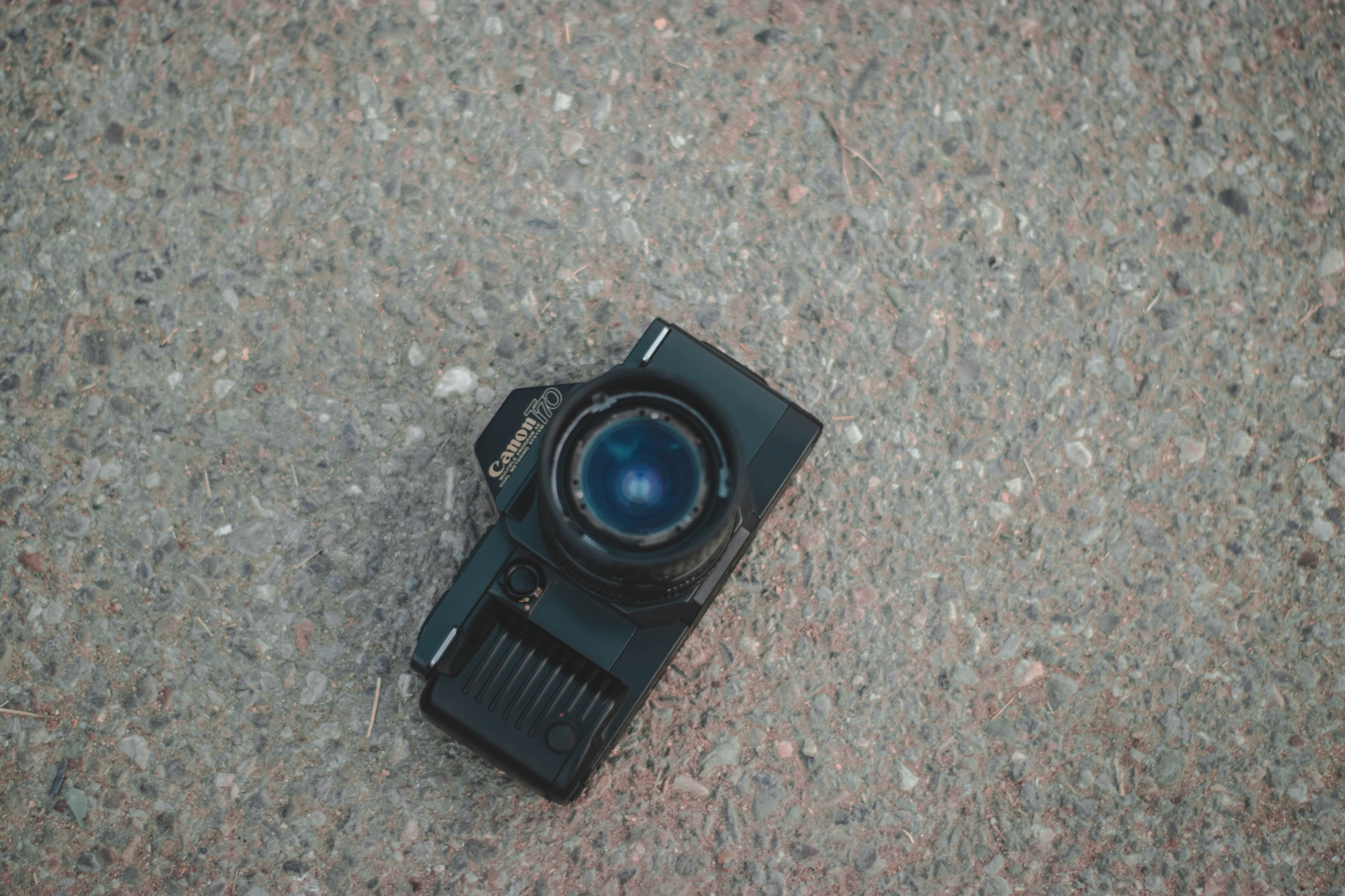 A Black Vintage Camera on a Concrete Ground · Free Stock Photo