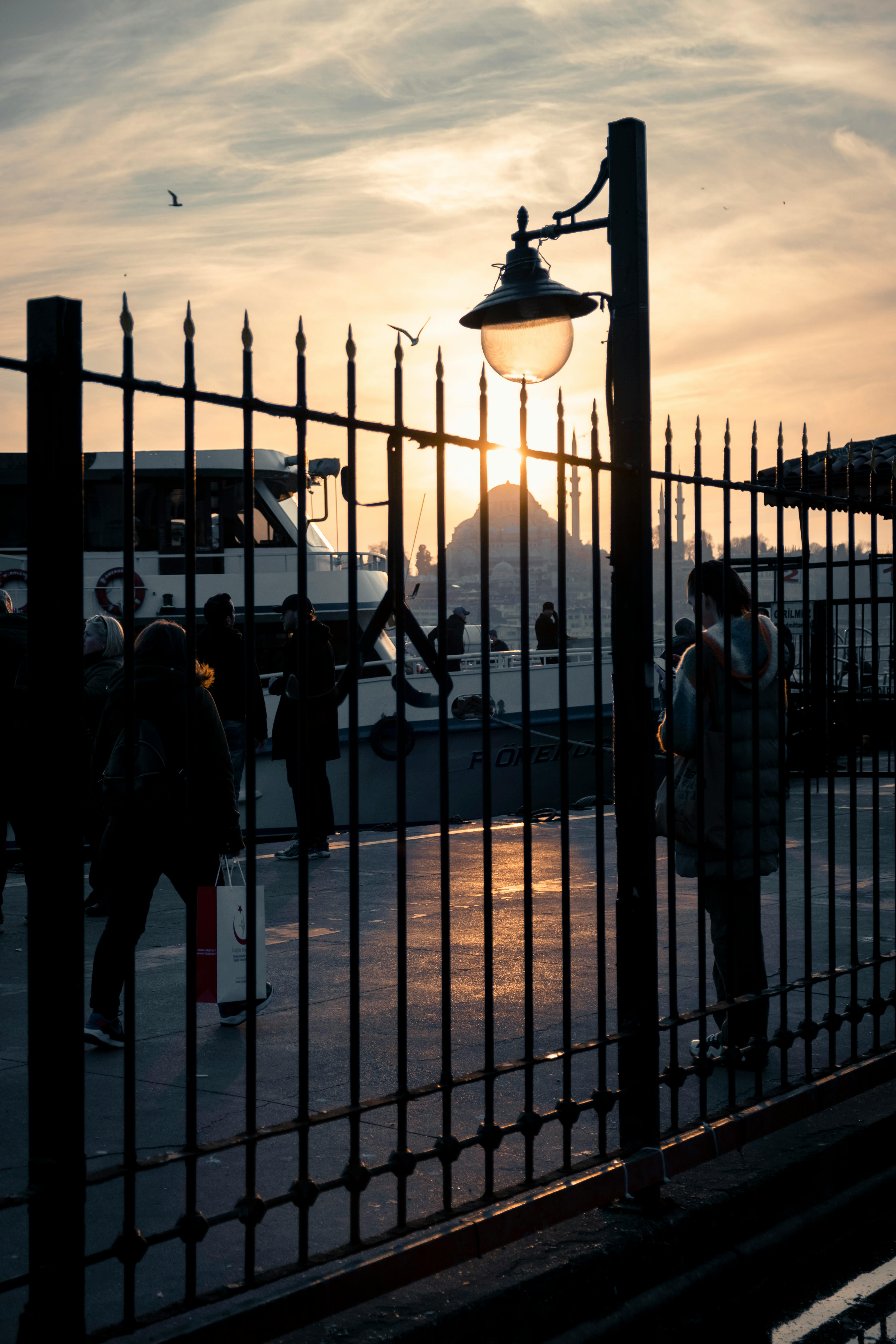 Man Standing Next to People Seated on Benches · Free Stock Photo