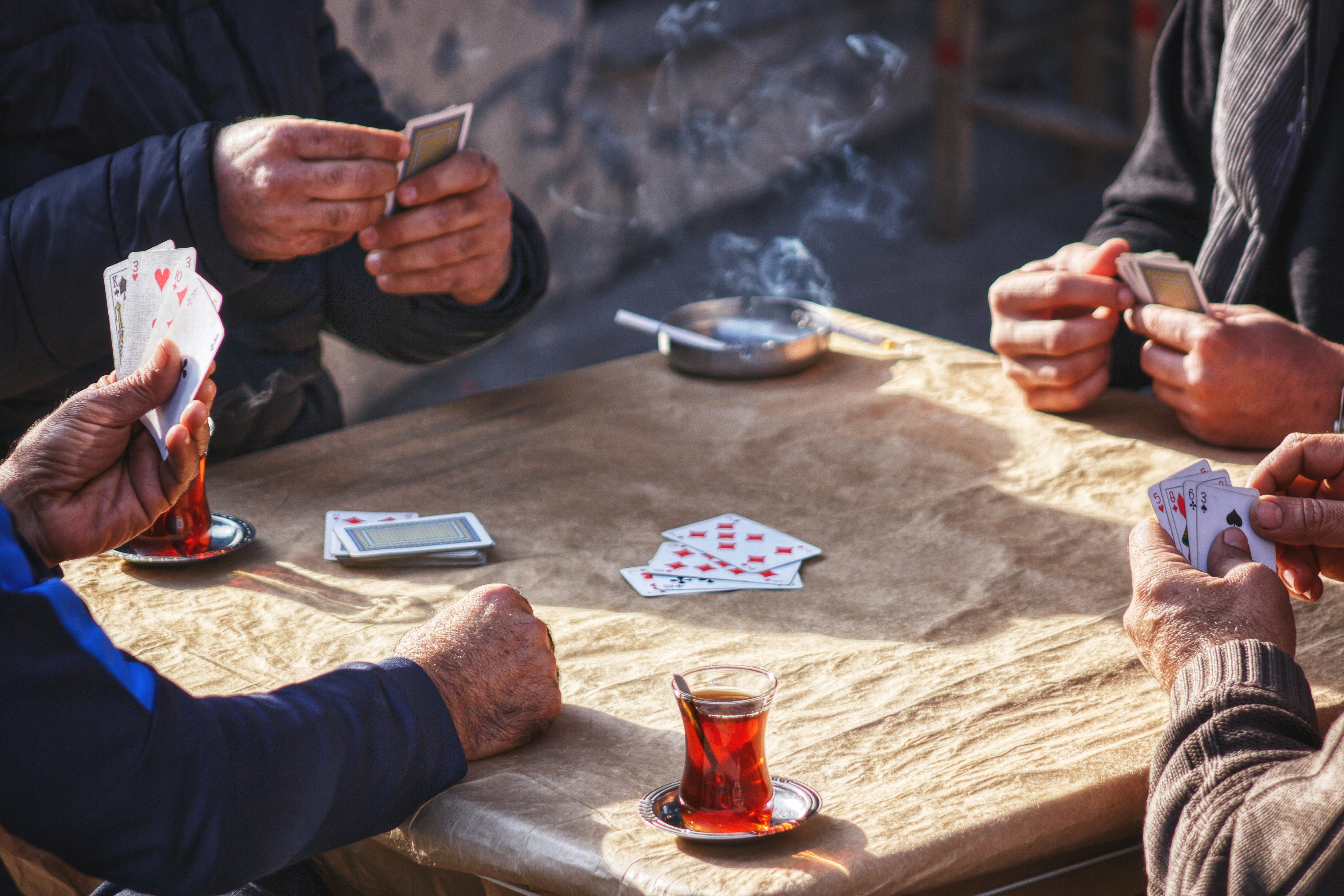 Hands of Men Playing Cards by Square Table · Free Stock Photo