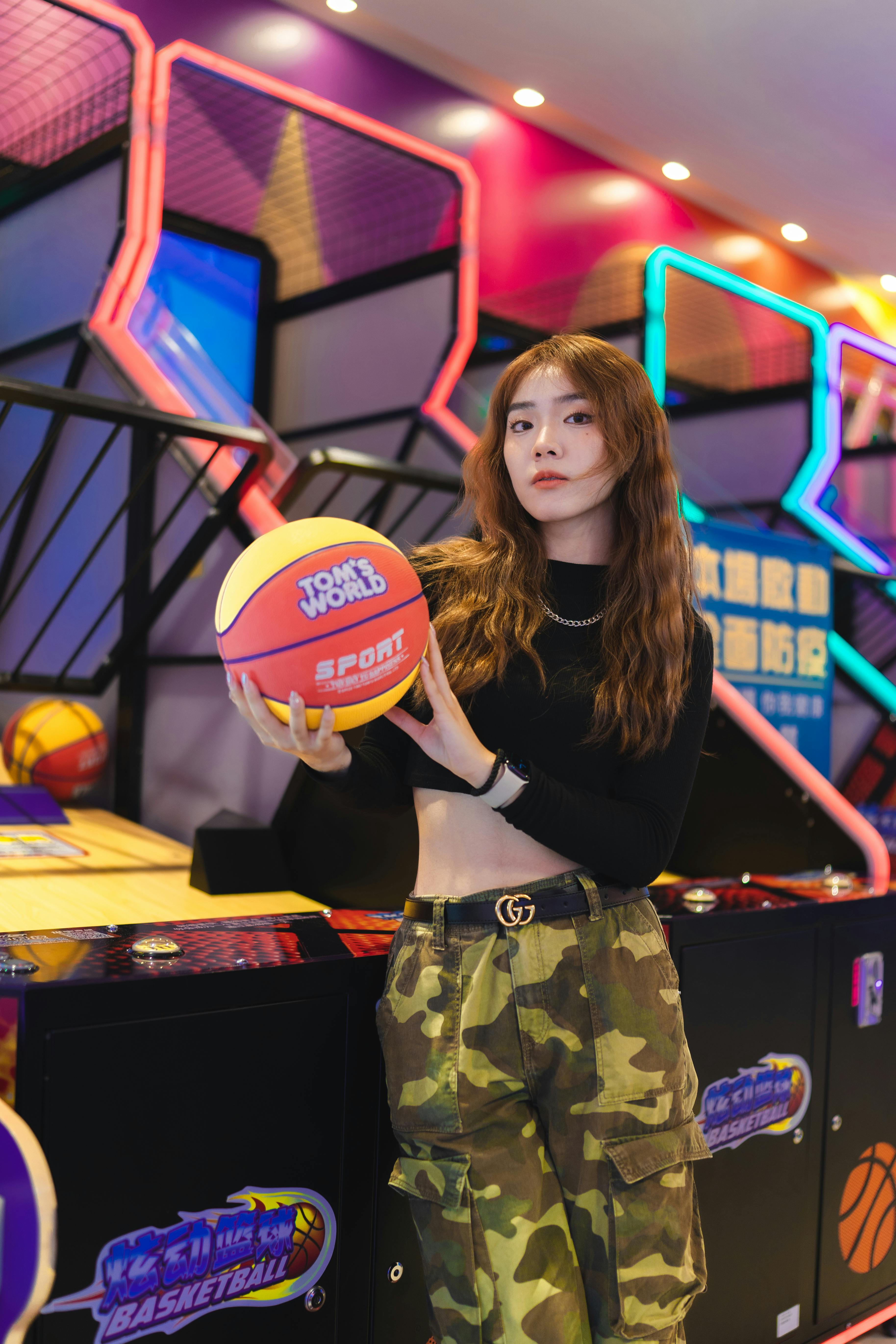 Brunette in Jacket Posing in Arcade · Free Stock Photo
