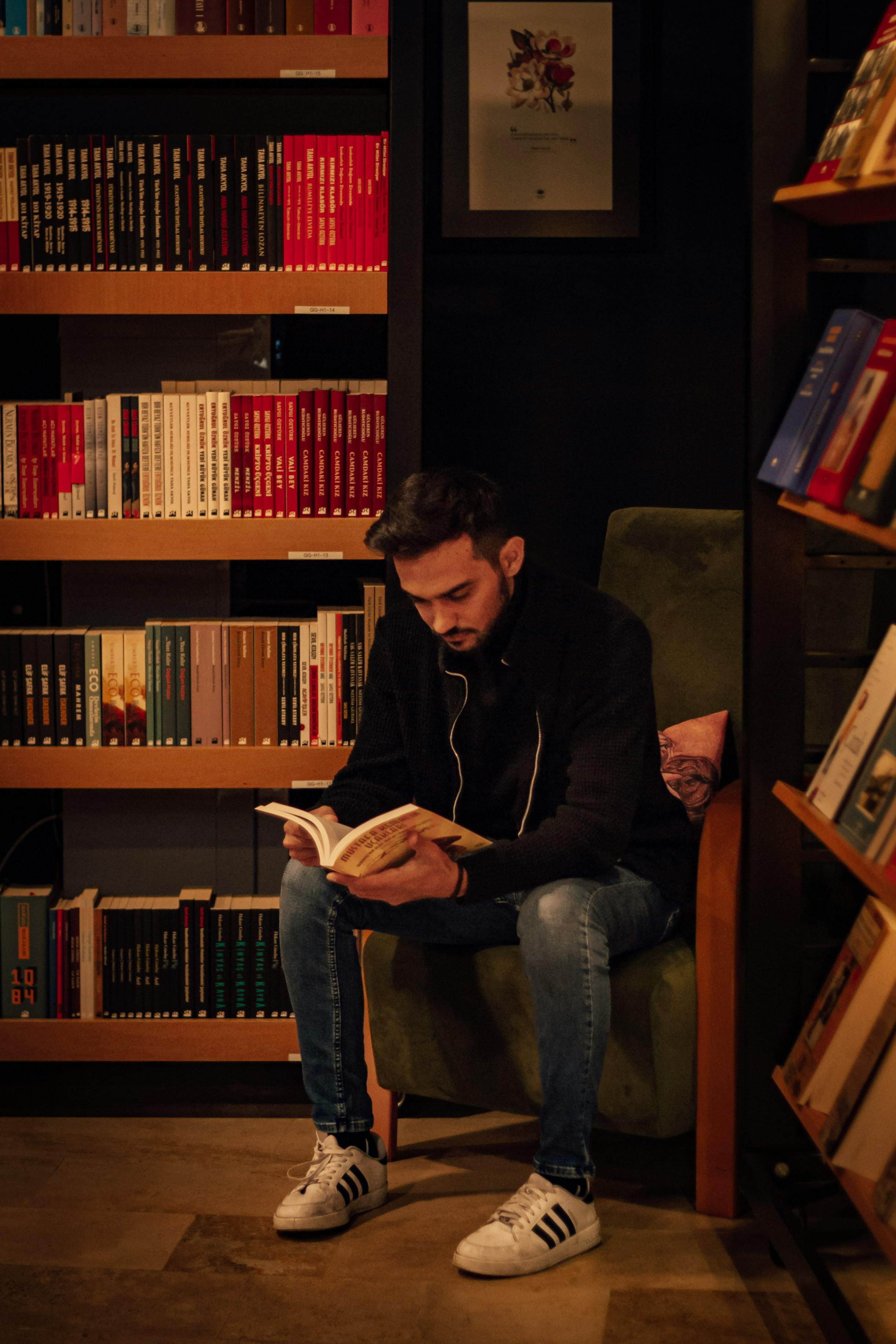 A Person Sitting on a Chair while Reading a Book · Free Stock Photo