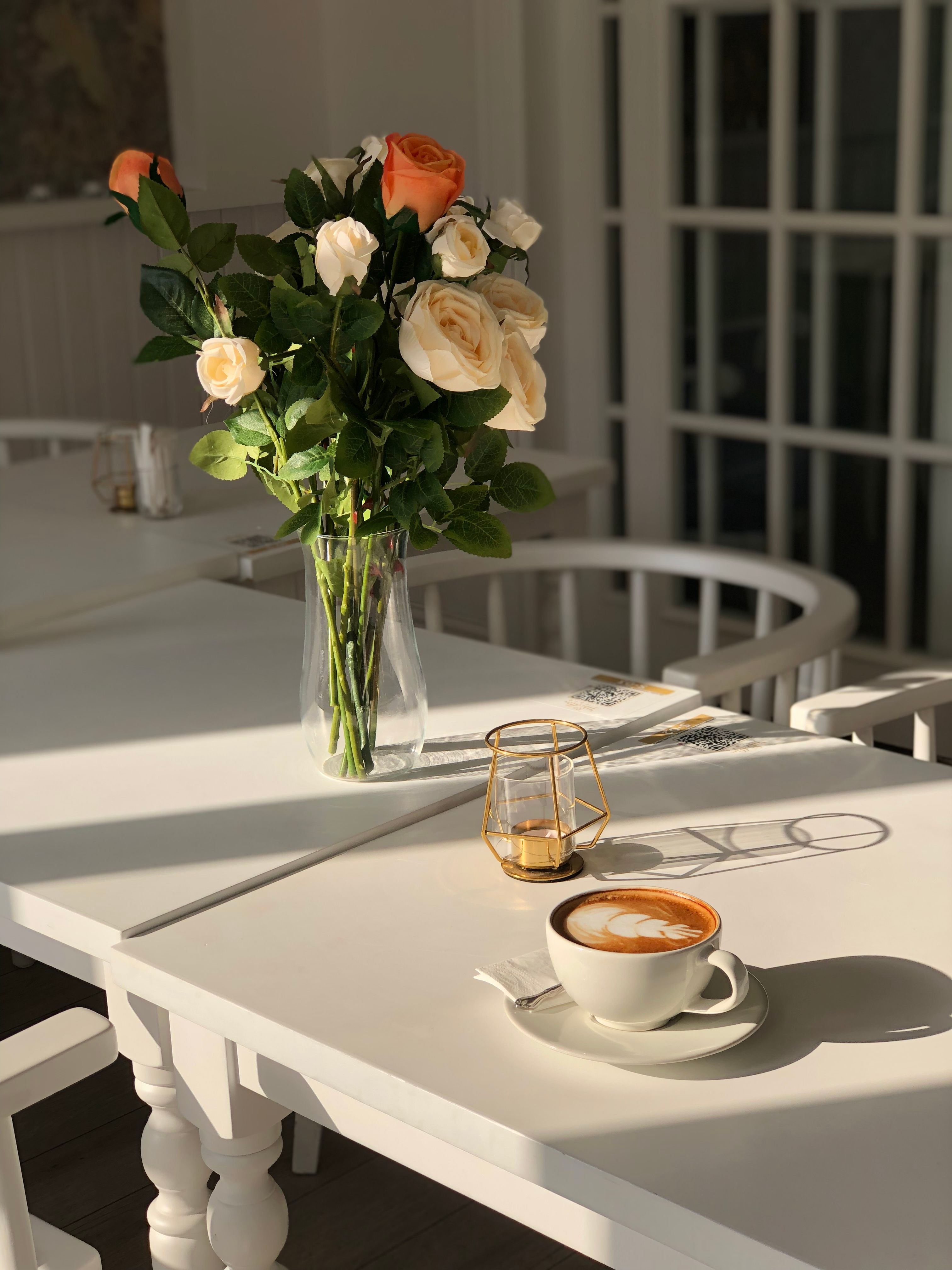 Cup of Coffee and Flowers on Cafe Table · Free Stock Photo