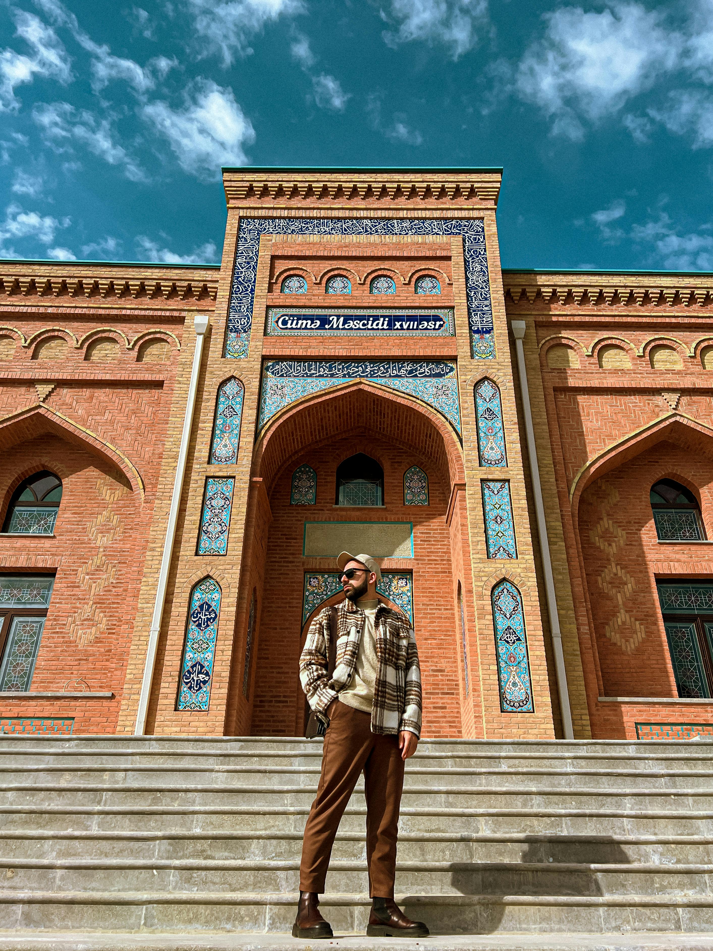 Man Posing near Ornamented Mosque Wall · Free Stock Photo