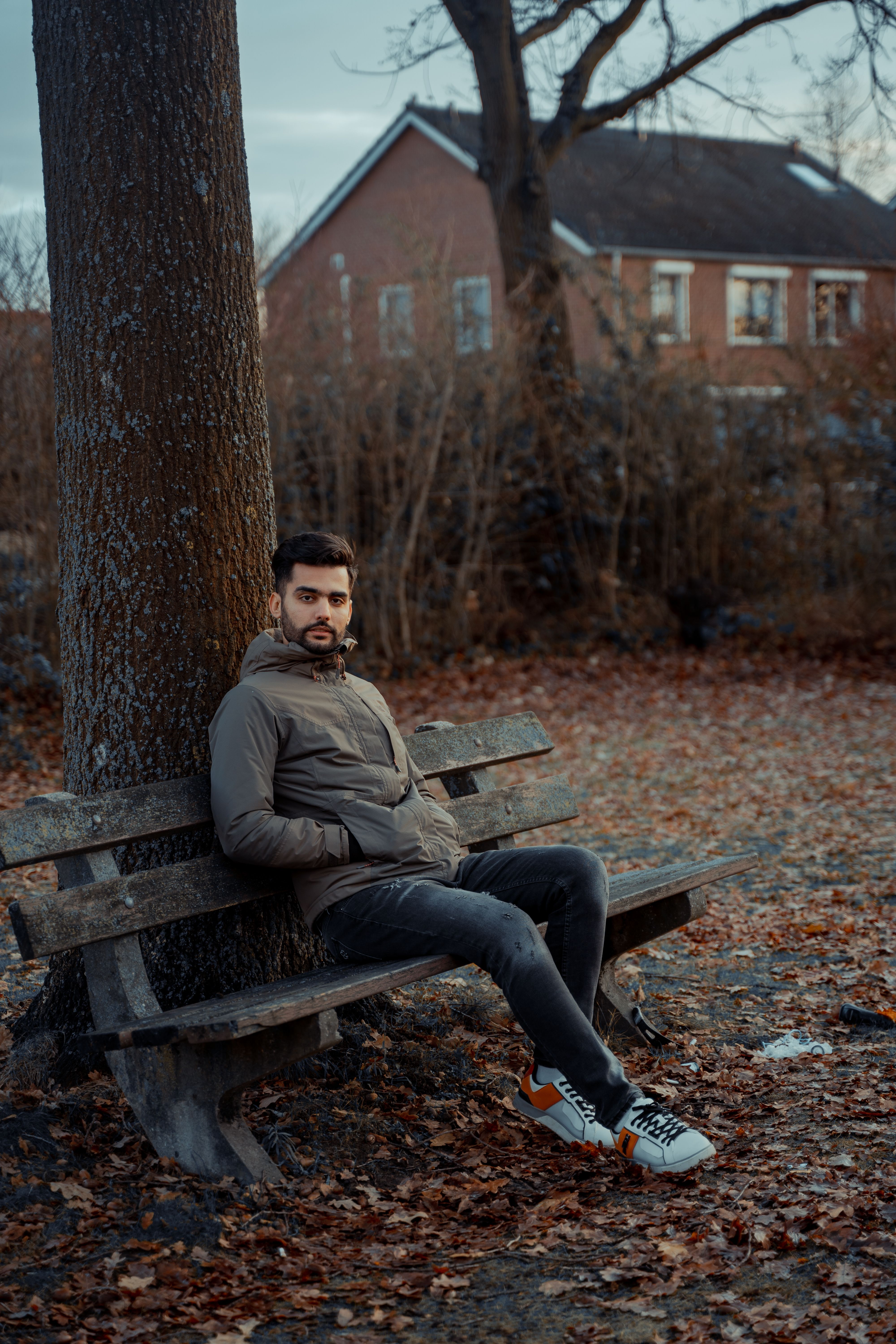Man Wearing a Jacket Sitting on a Bench · Free Stock Photo