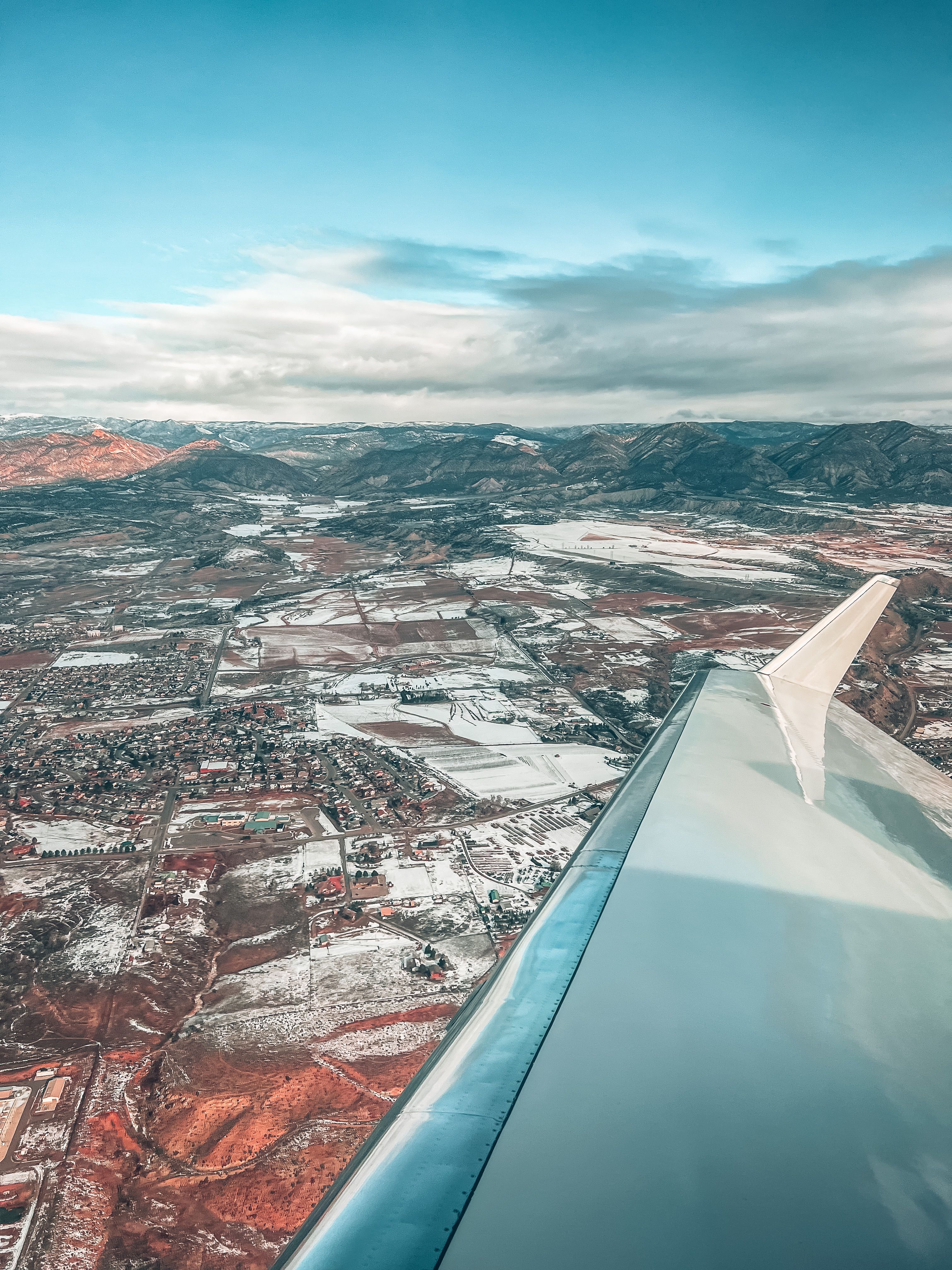 Wing of an Airplane Flying over a Town · Free Stock Photo