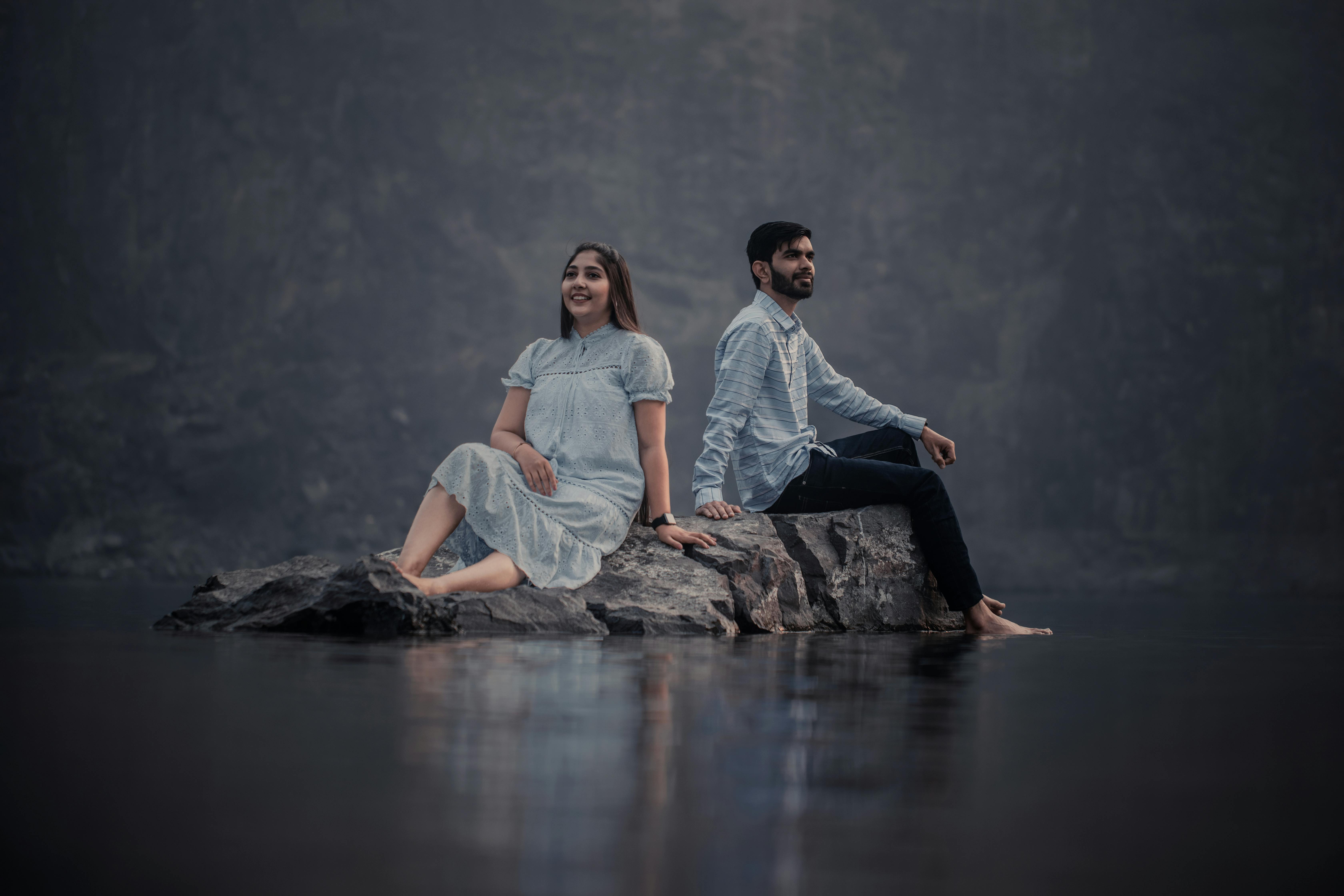 A Couple Sitting on Big Rock while Looking Afar · Free Stock Photo