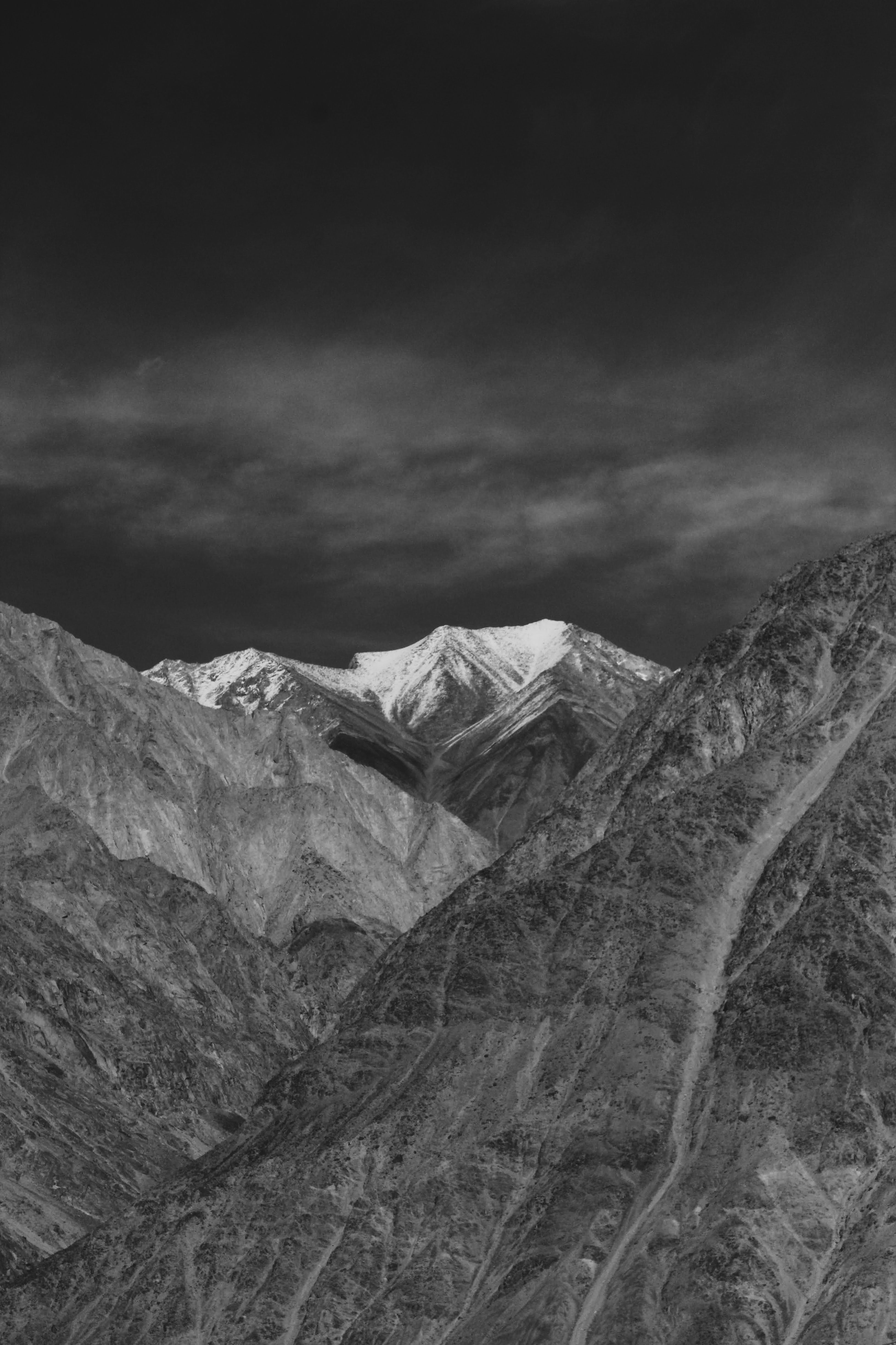 Grayscale Photo of Mountain Near Body of Water · Free Stock Photo