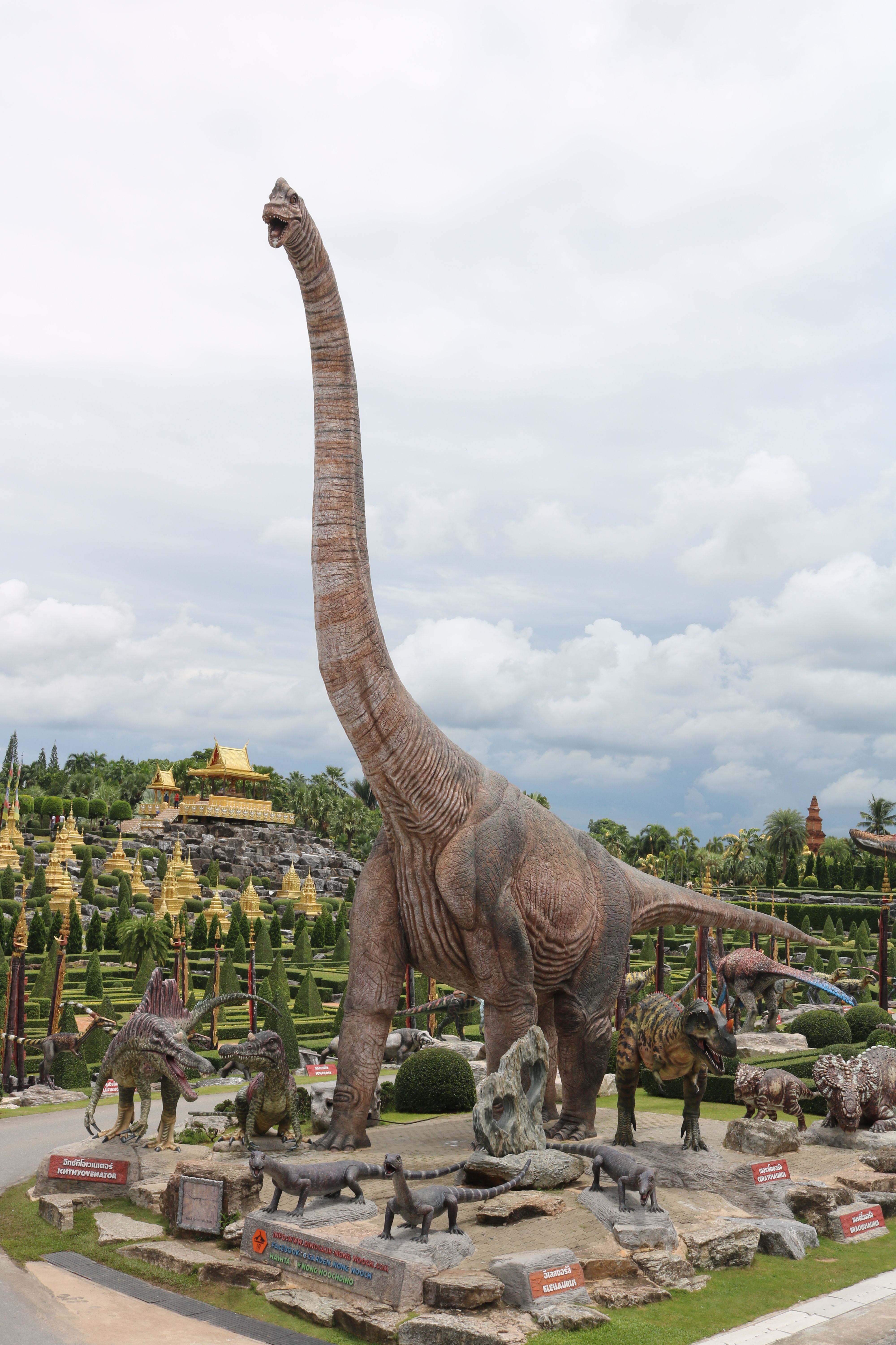 Dinosaur Statues in a Park, and Golden Roofs in Background · Free Stock ...