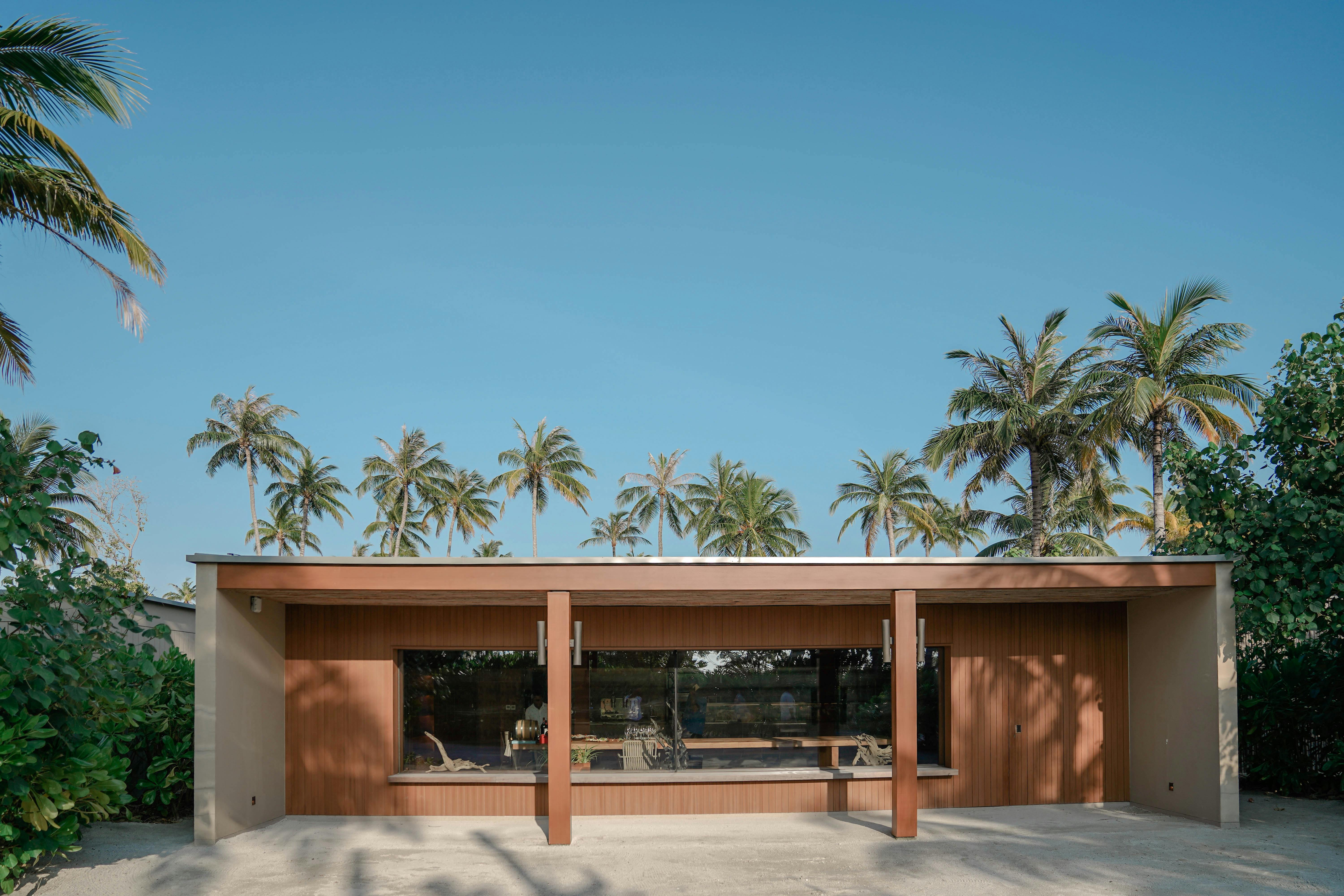 Palm Trees around Building on Beach · Free Stock Photo