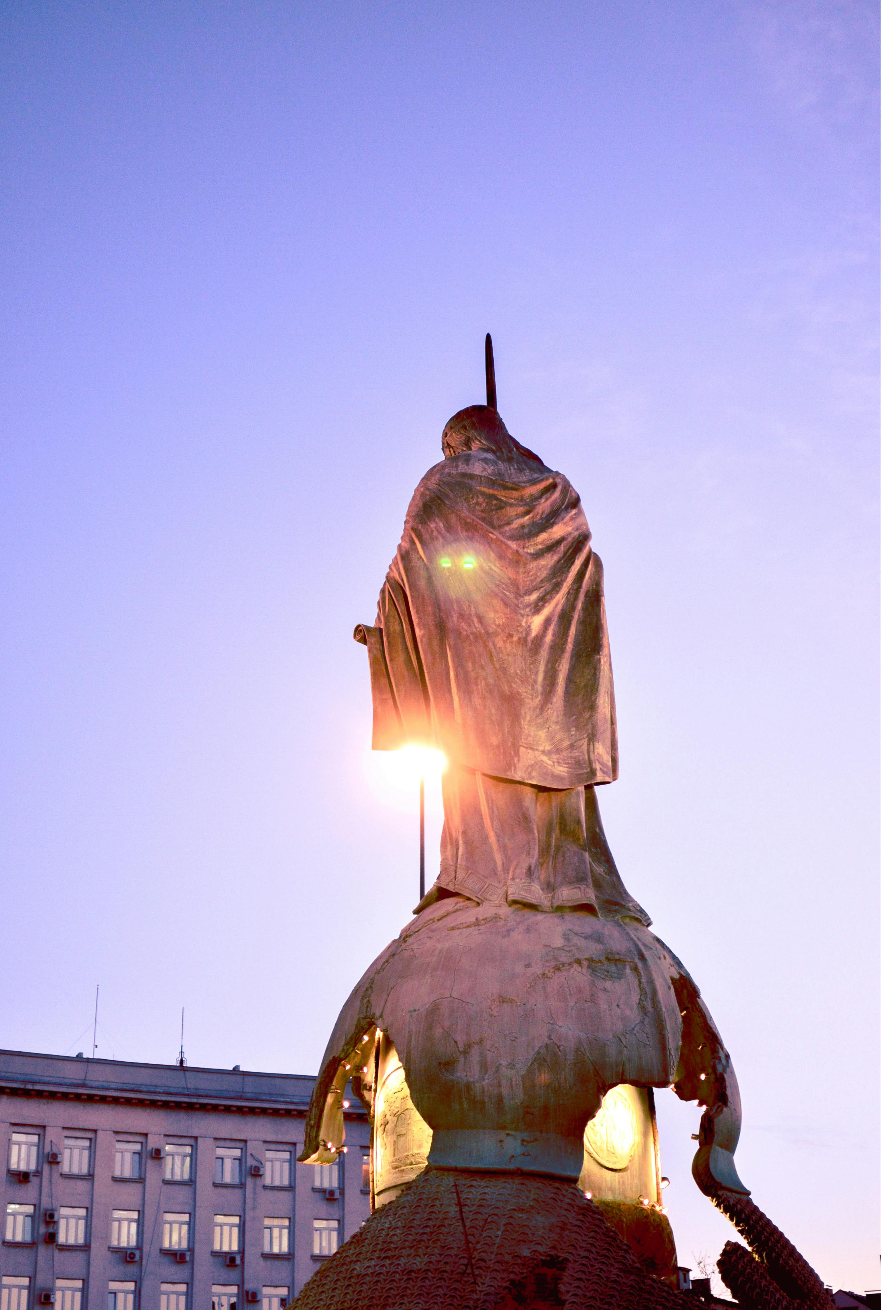 Man Sitting with Camera under Monument · Free Stock Photo