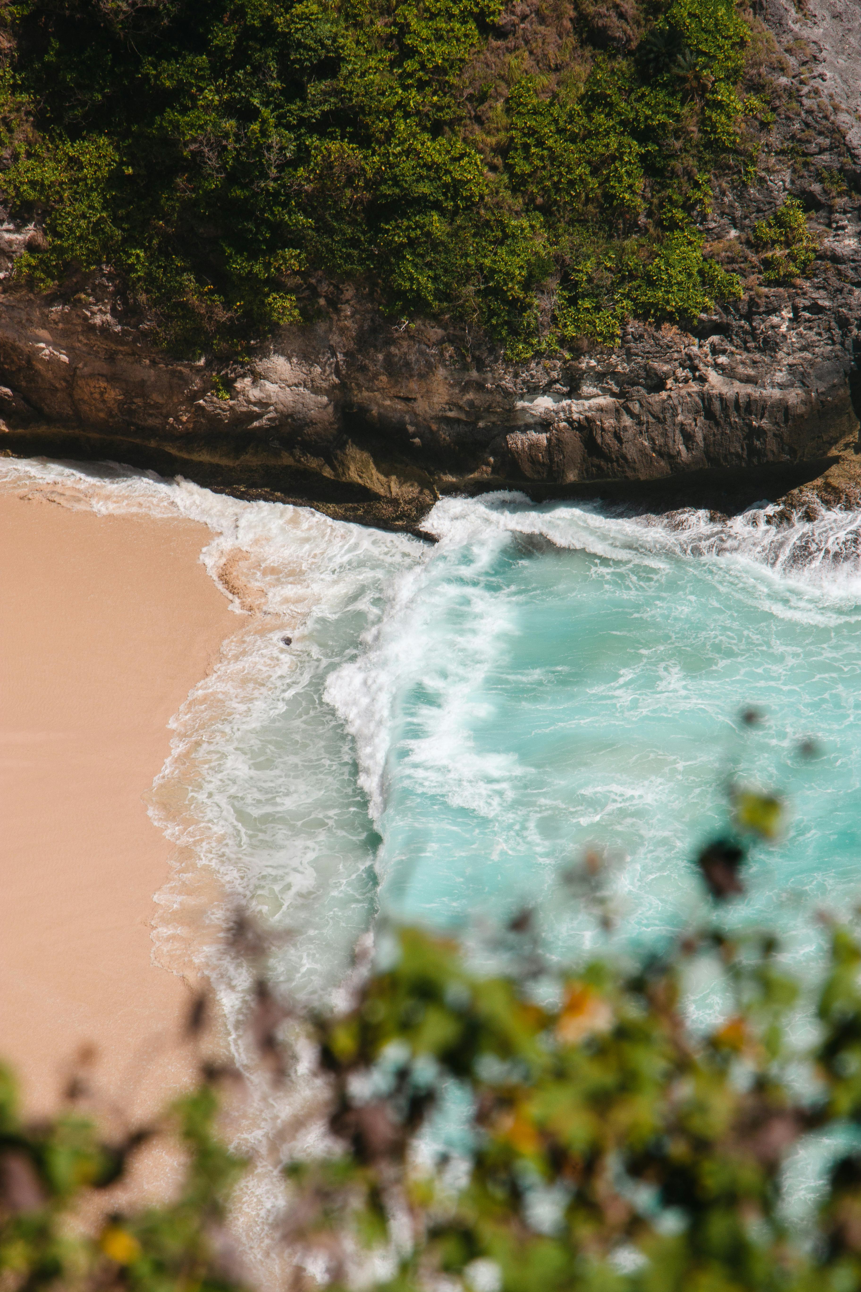 Aerial View of Beach Near Rock Formation · Free Stock Photo