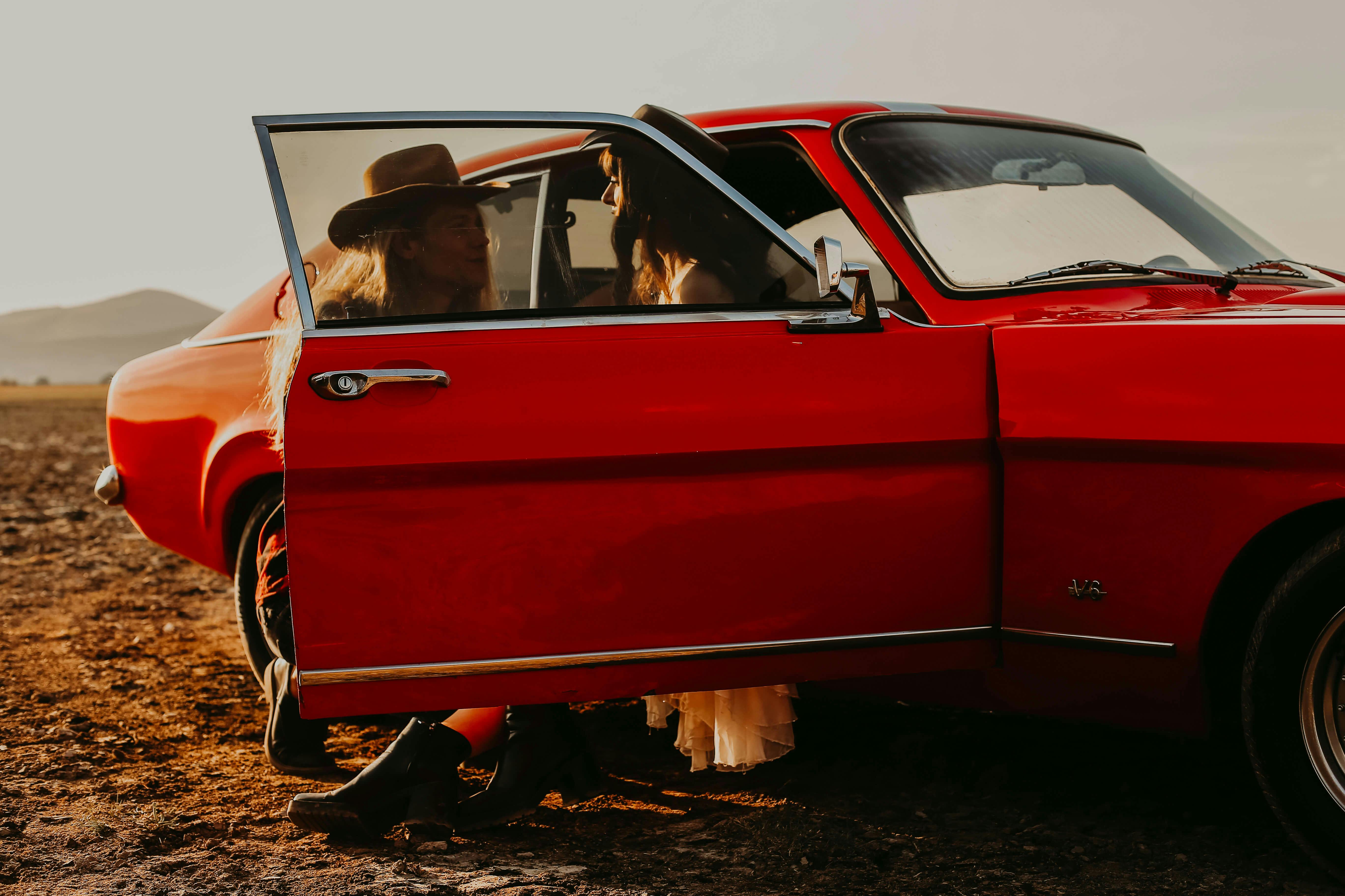 Couple Wearing Cowboy Hats in Vintage Car · Free Stock Photo