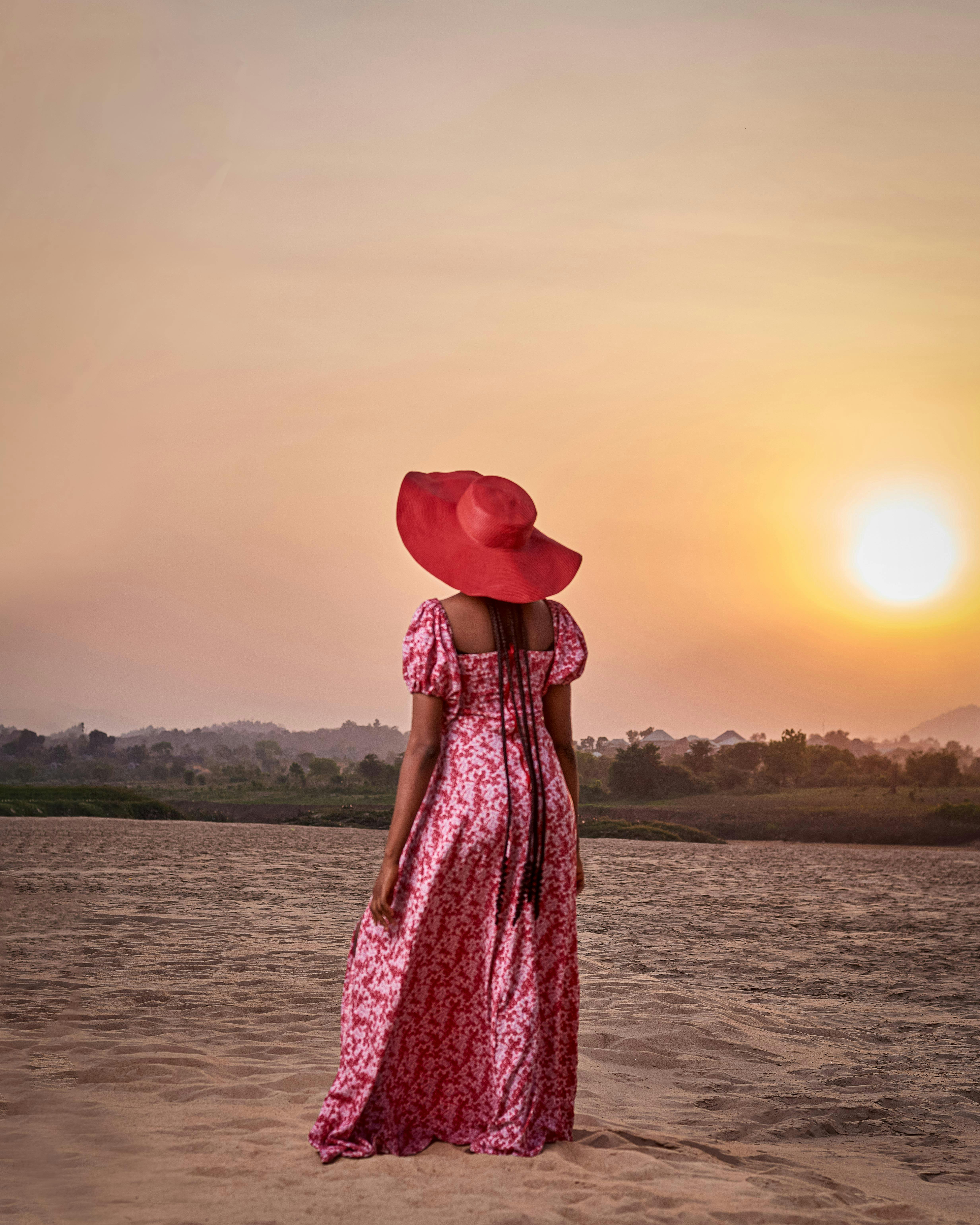 A Woman in Red Dress Wearing Red Sun Hat · Free Stock Photo