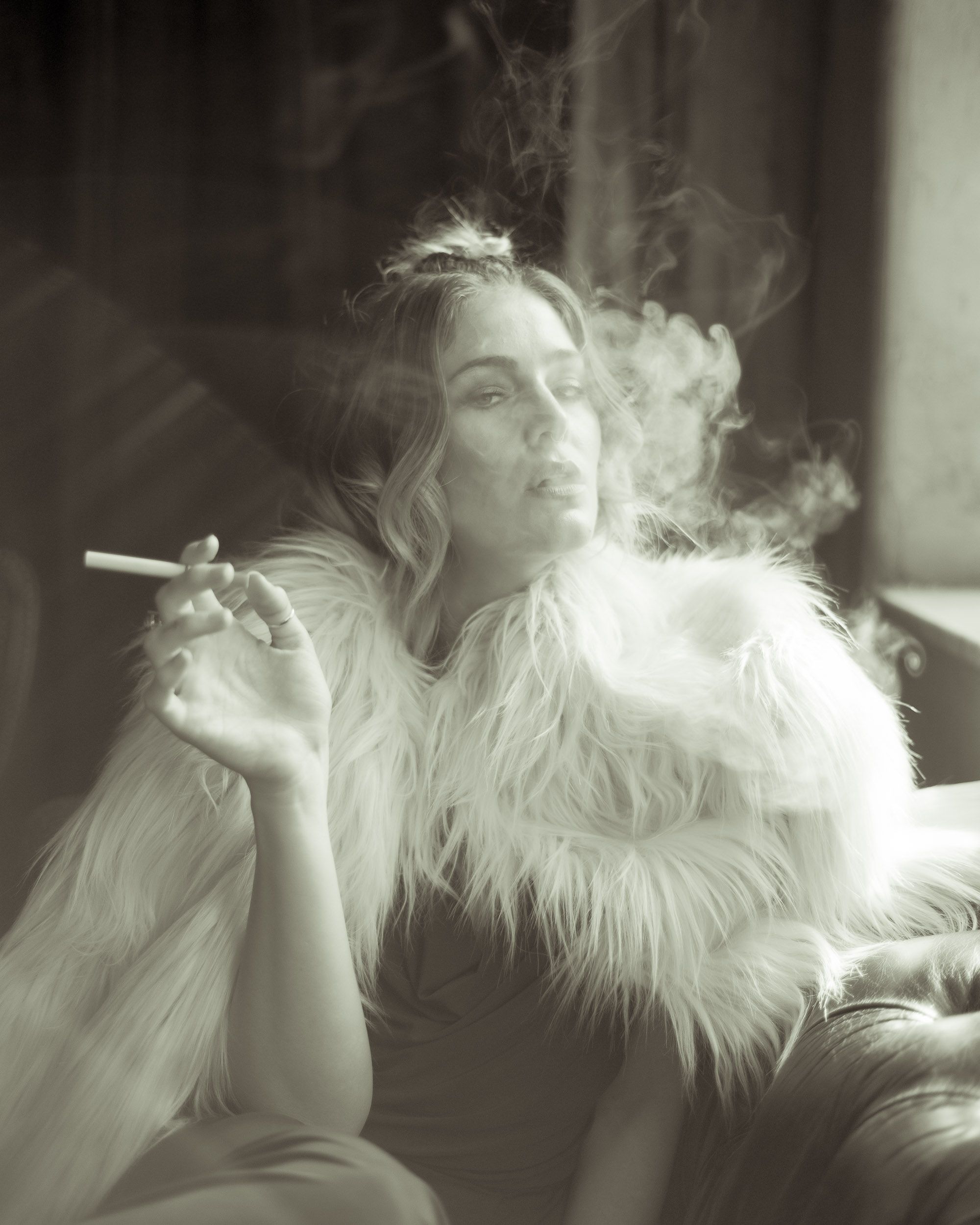 A Grayscale Photo of a Woman Smoking Cigarette while Sitting on the ...