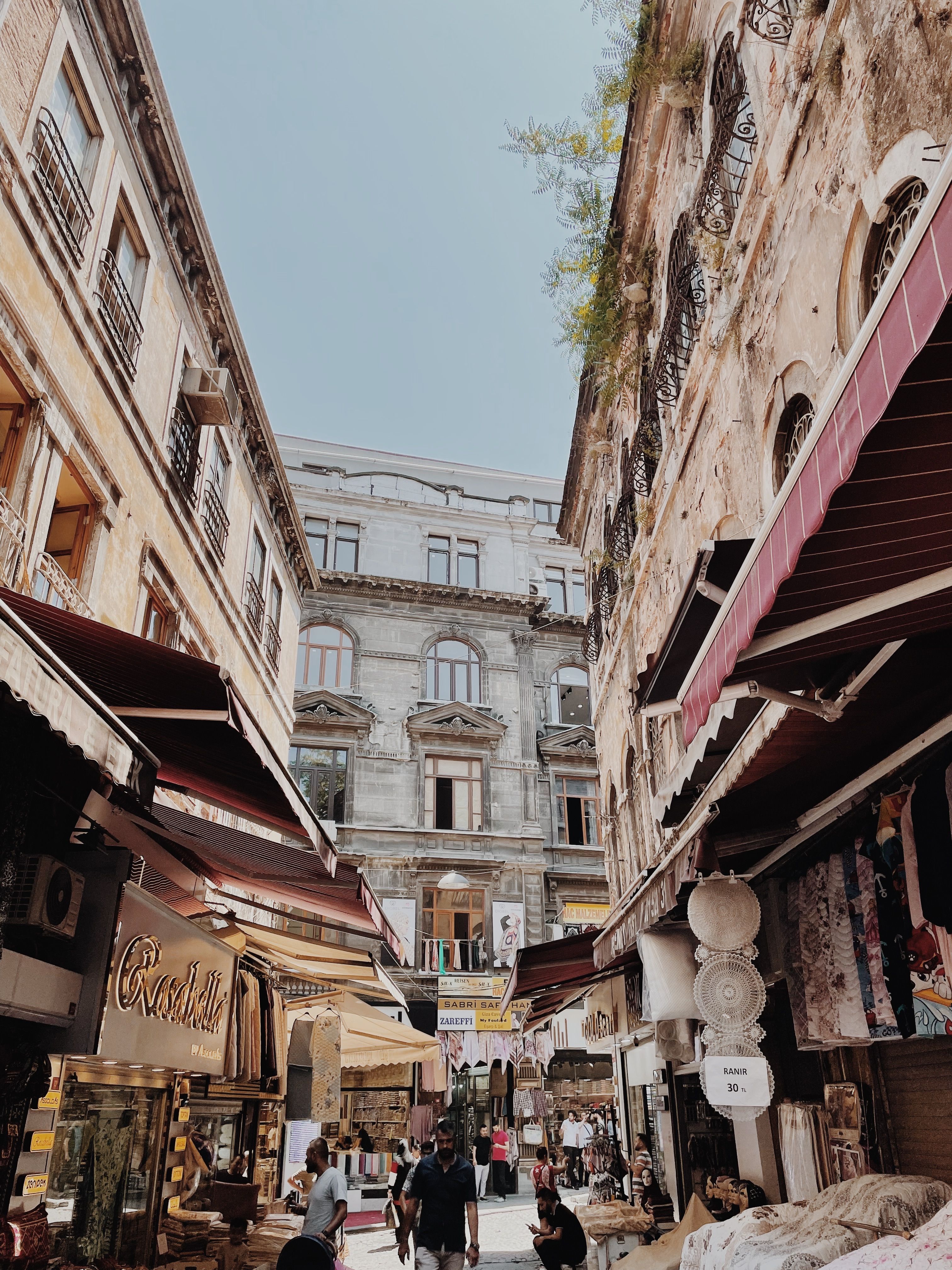 View of a Crowded Alley between Buildings with Shops and Restaurants ...