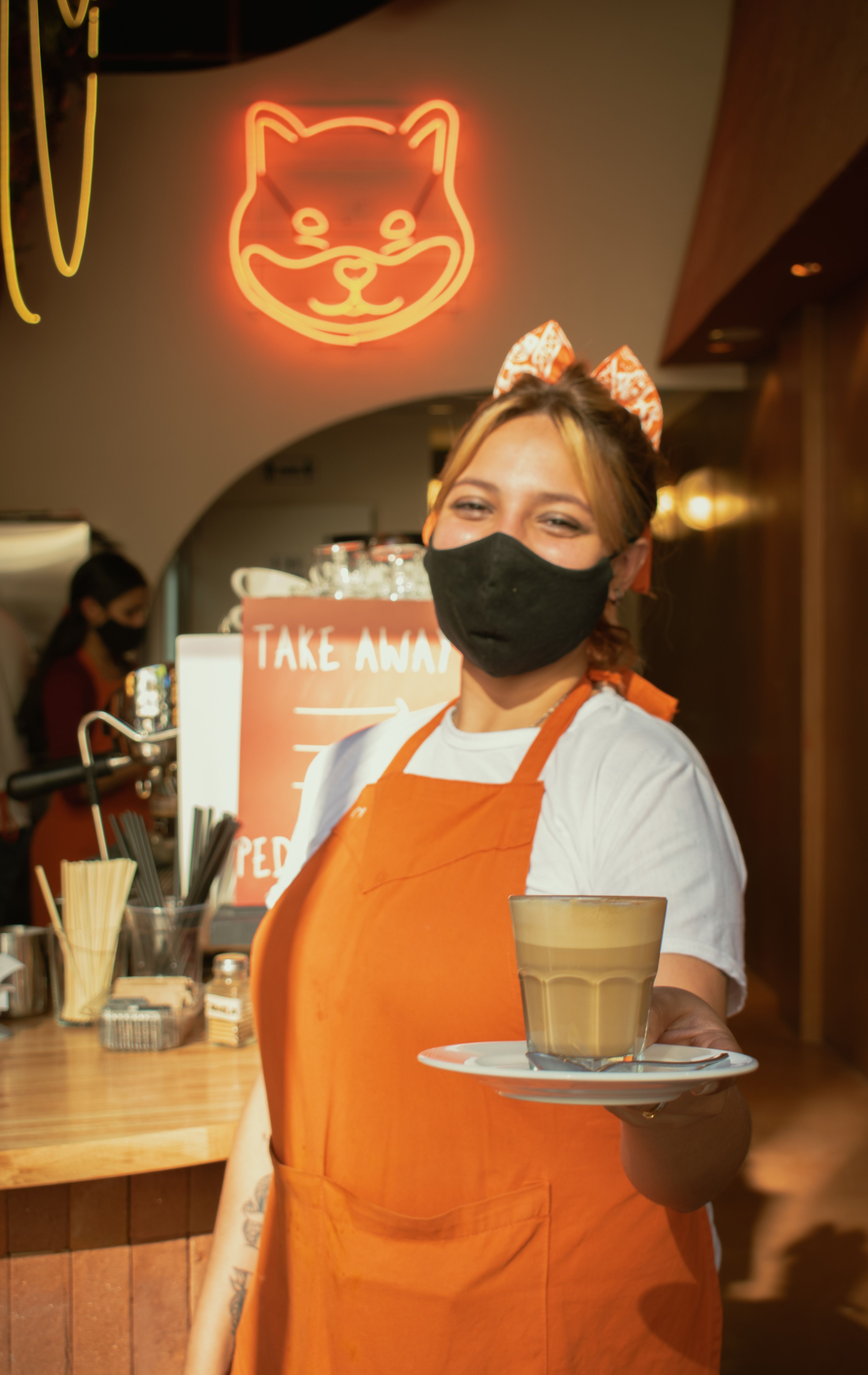 Barista in Face Mask and Apron with Coffee · Free Stock Photo