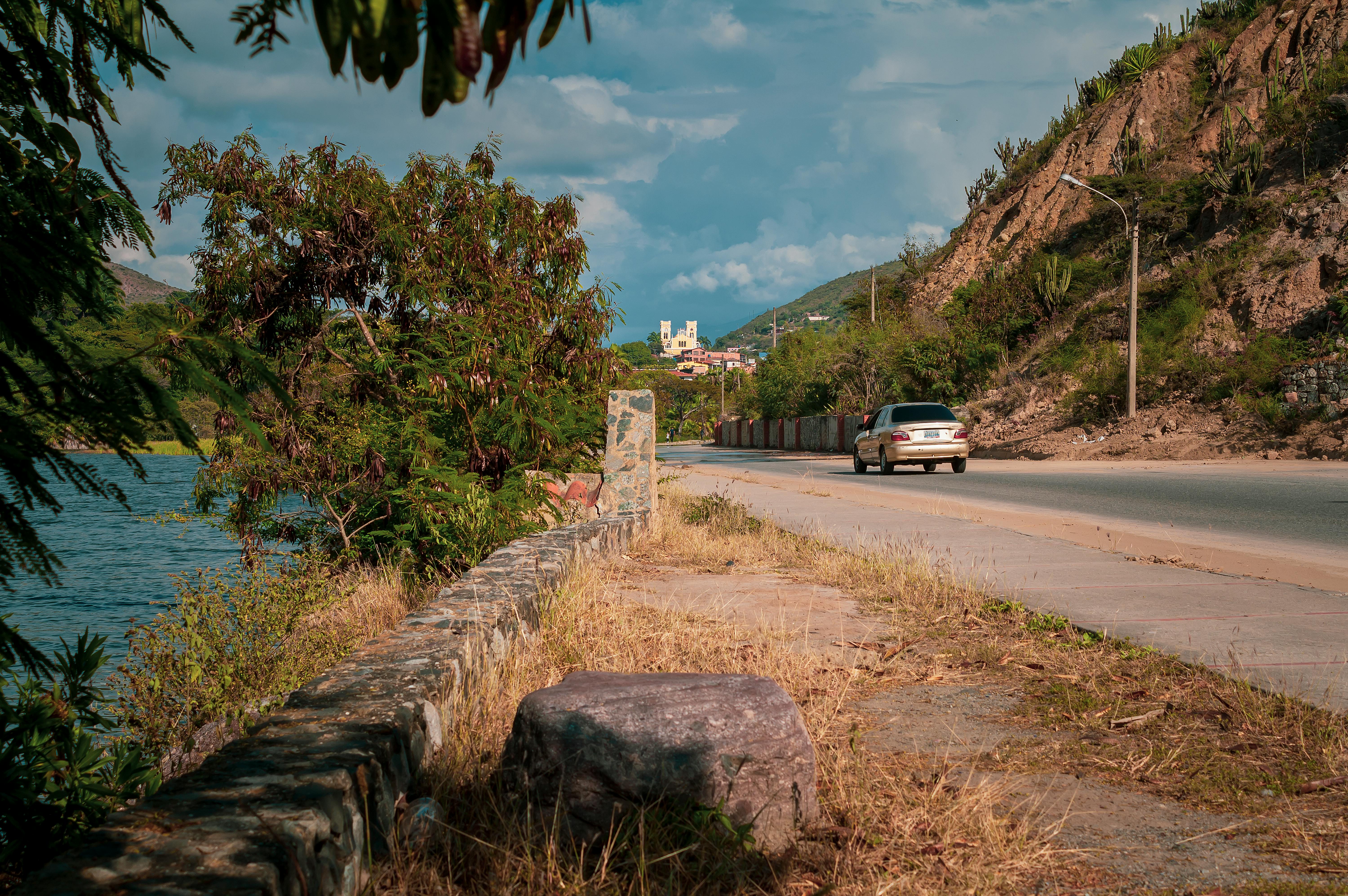 Car Driving on Road near Sea in Mountains Landscape · Free Stock Photo