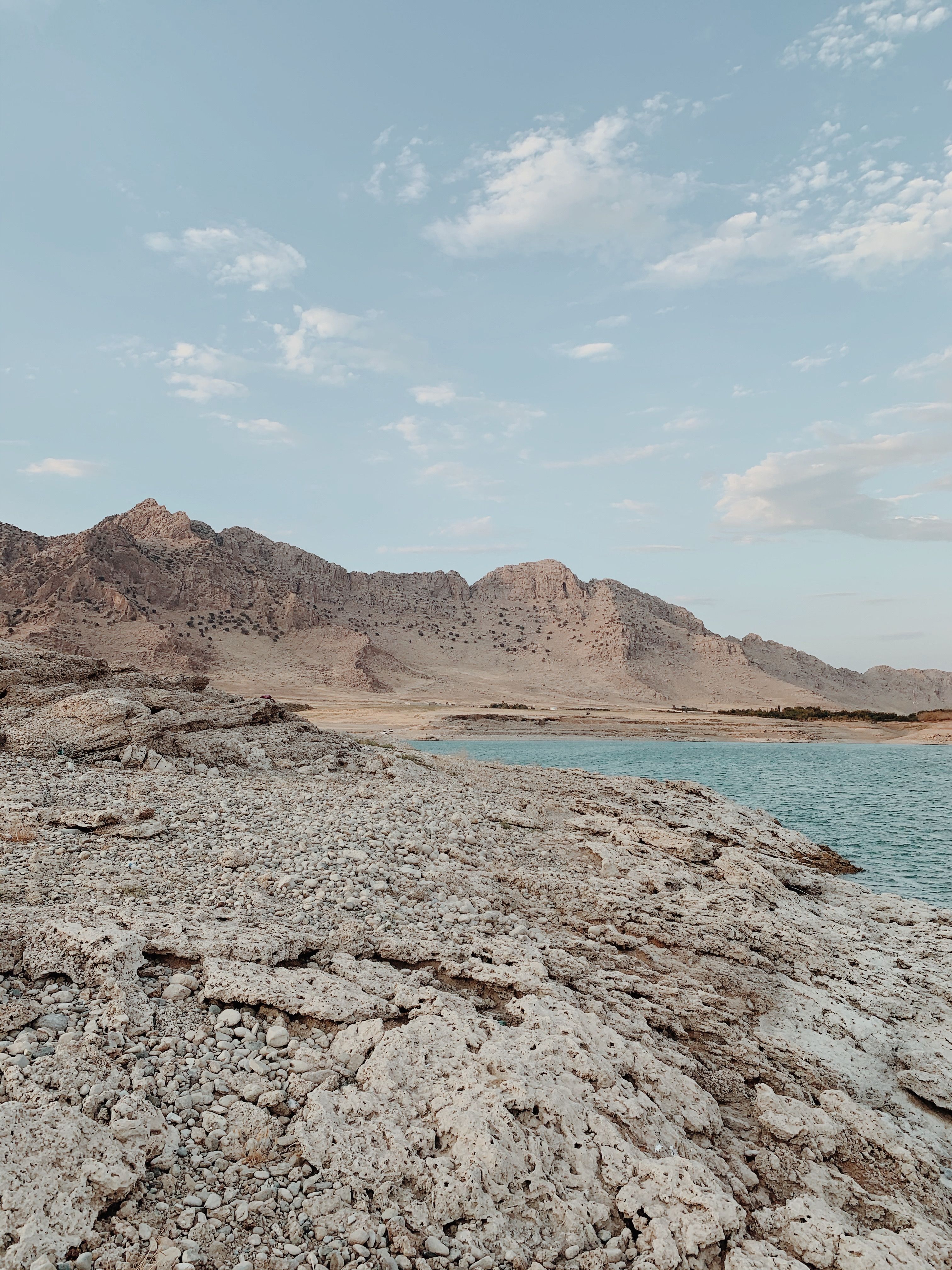 View of Dry Land and Mountains near a Body of Water · Free Stock Photo
