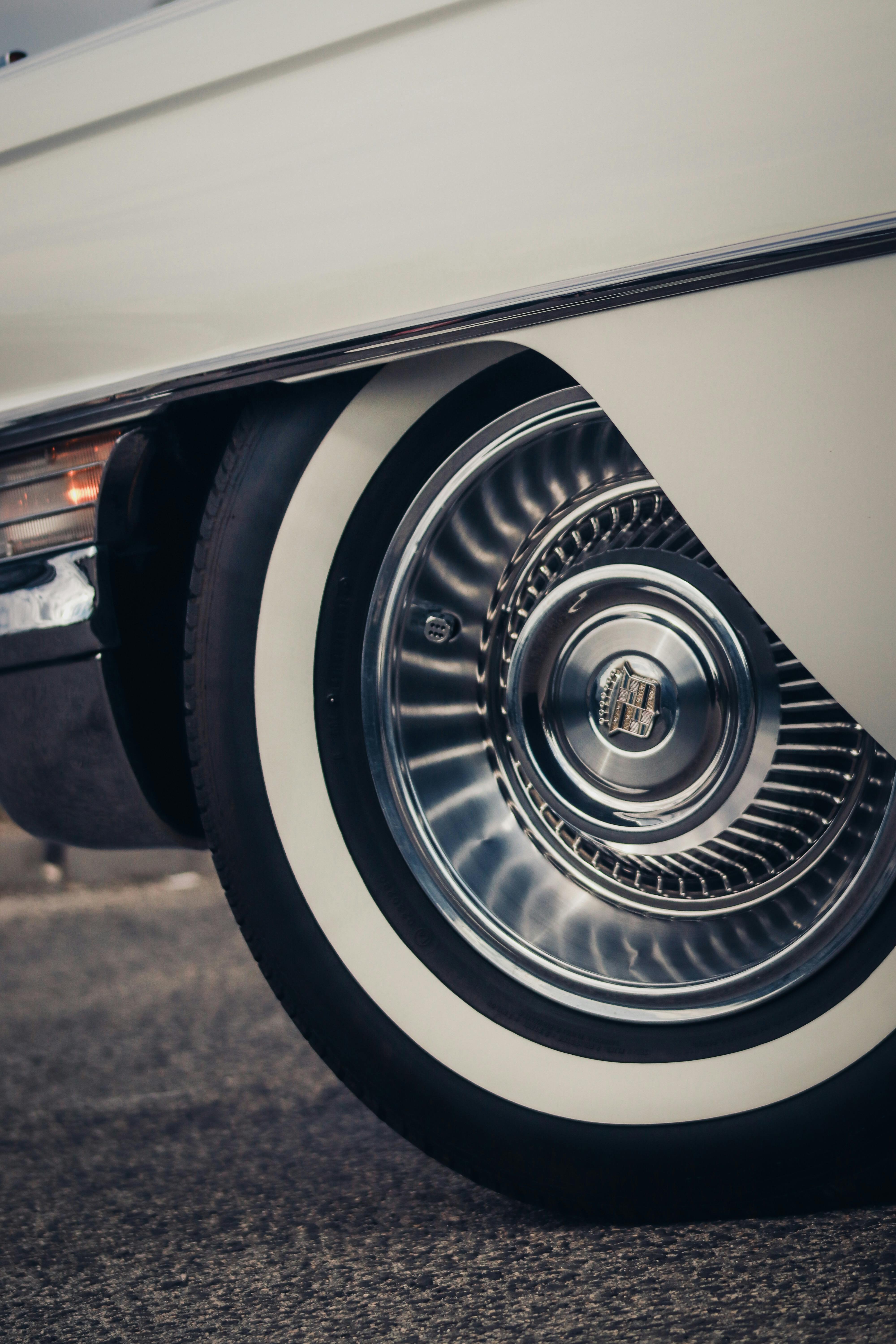 Retro car driving on city road near building · Free Stock Photo