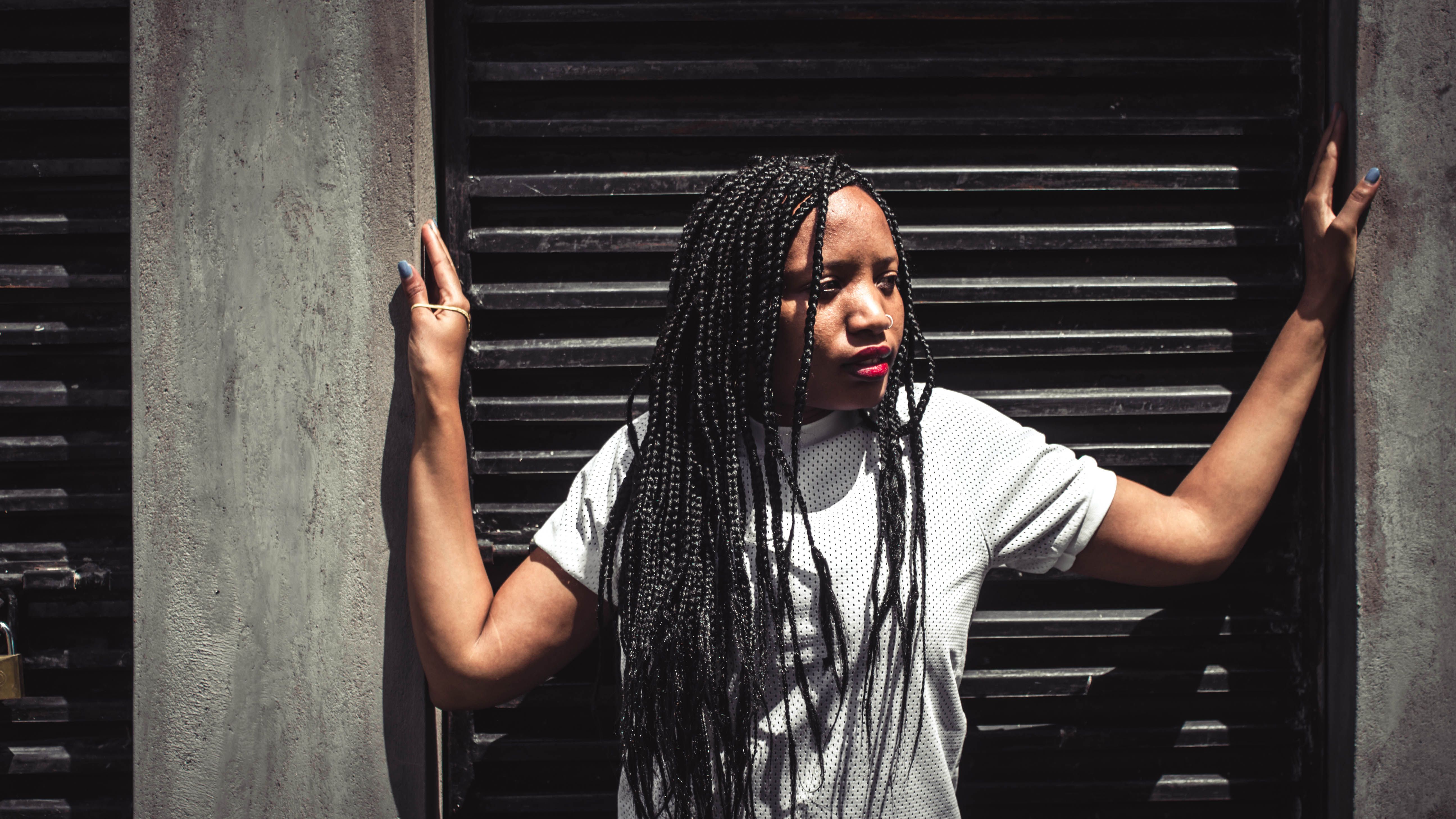 Woman with Braided Hair Standing Between Concrete Columns · Free Stock ...