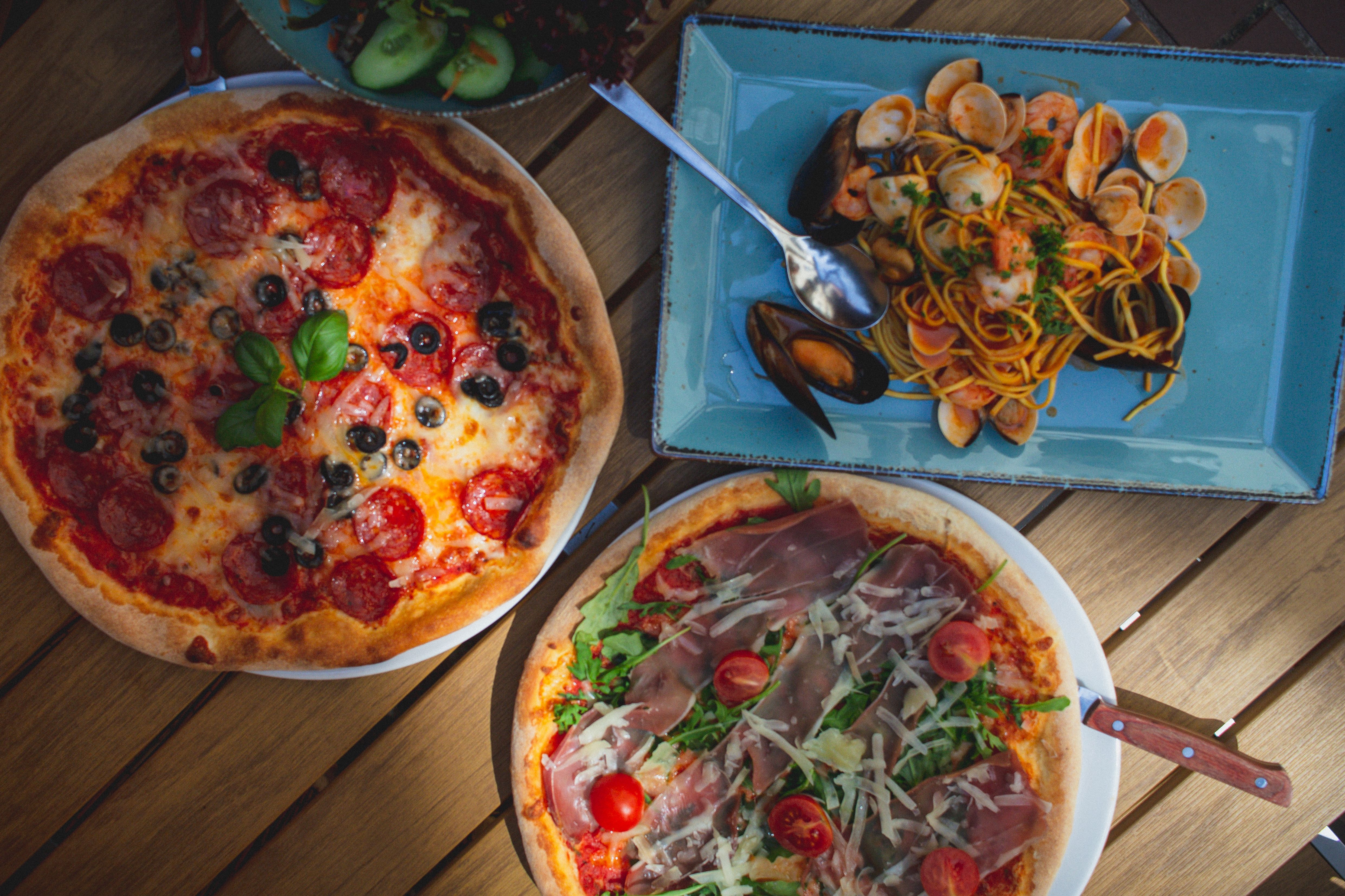 Delicious Pizzas and a Plate of Seafood Marinara · Free Stock Photo