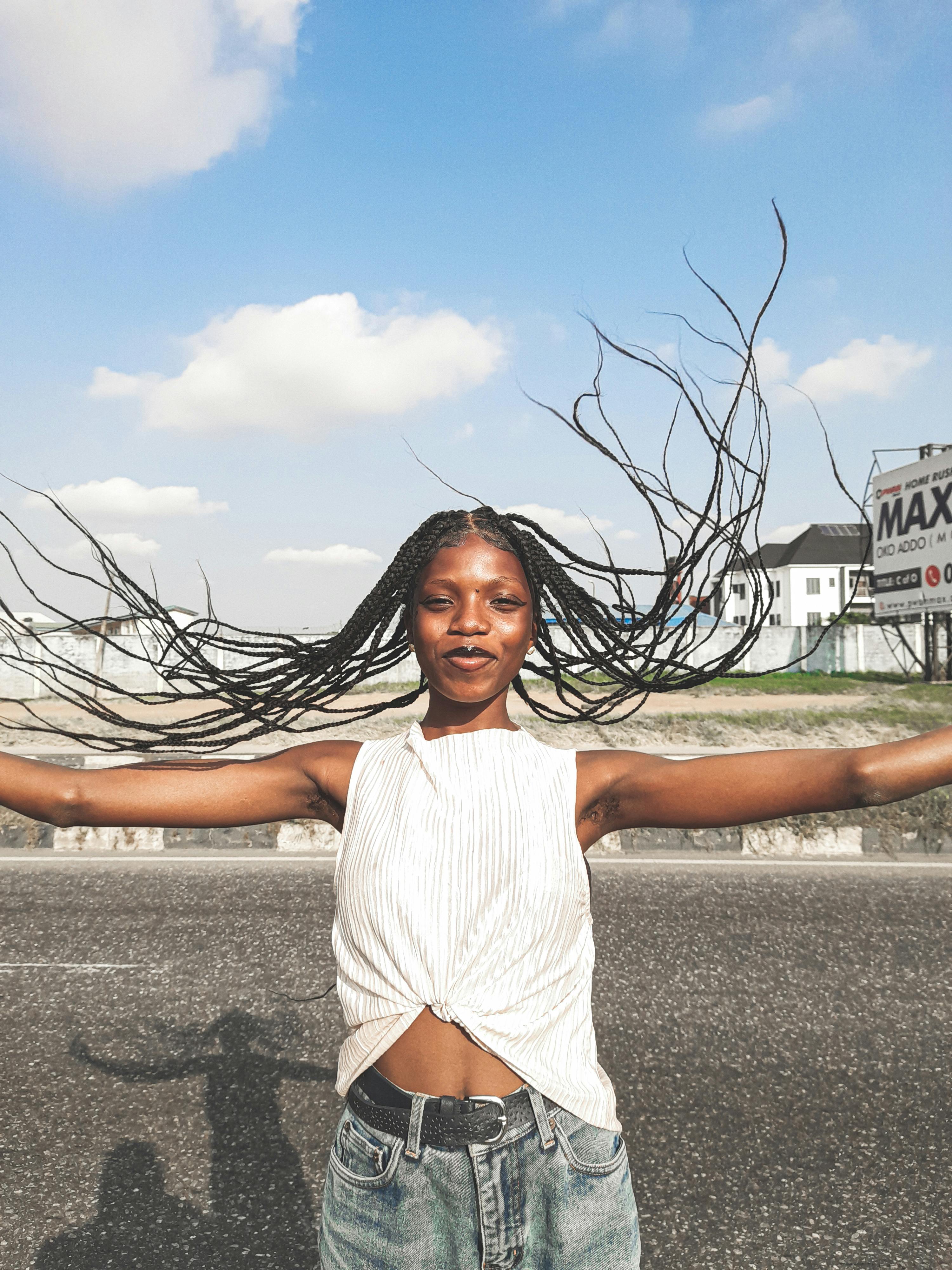A Woman Standing on the Road Flipping Her Hair while Smiling at the ...