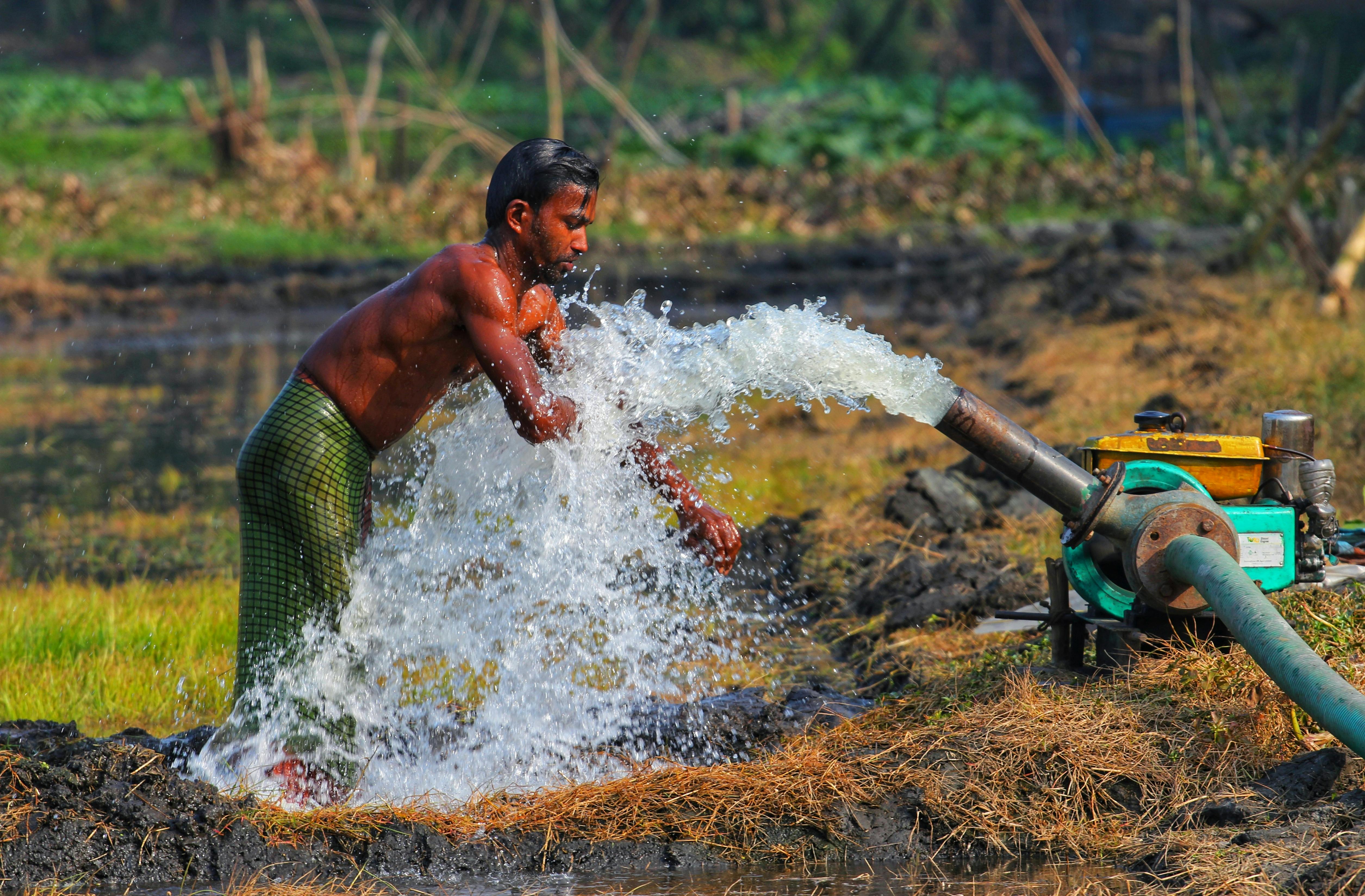 Man Washing himself in Water Pump · Free Stock Photo