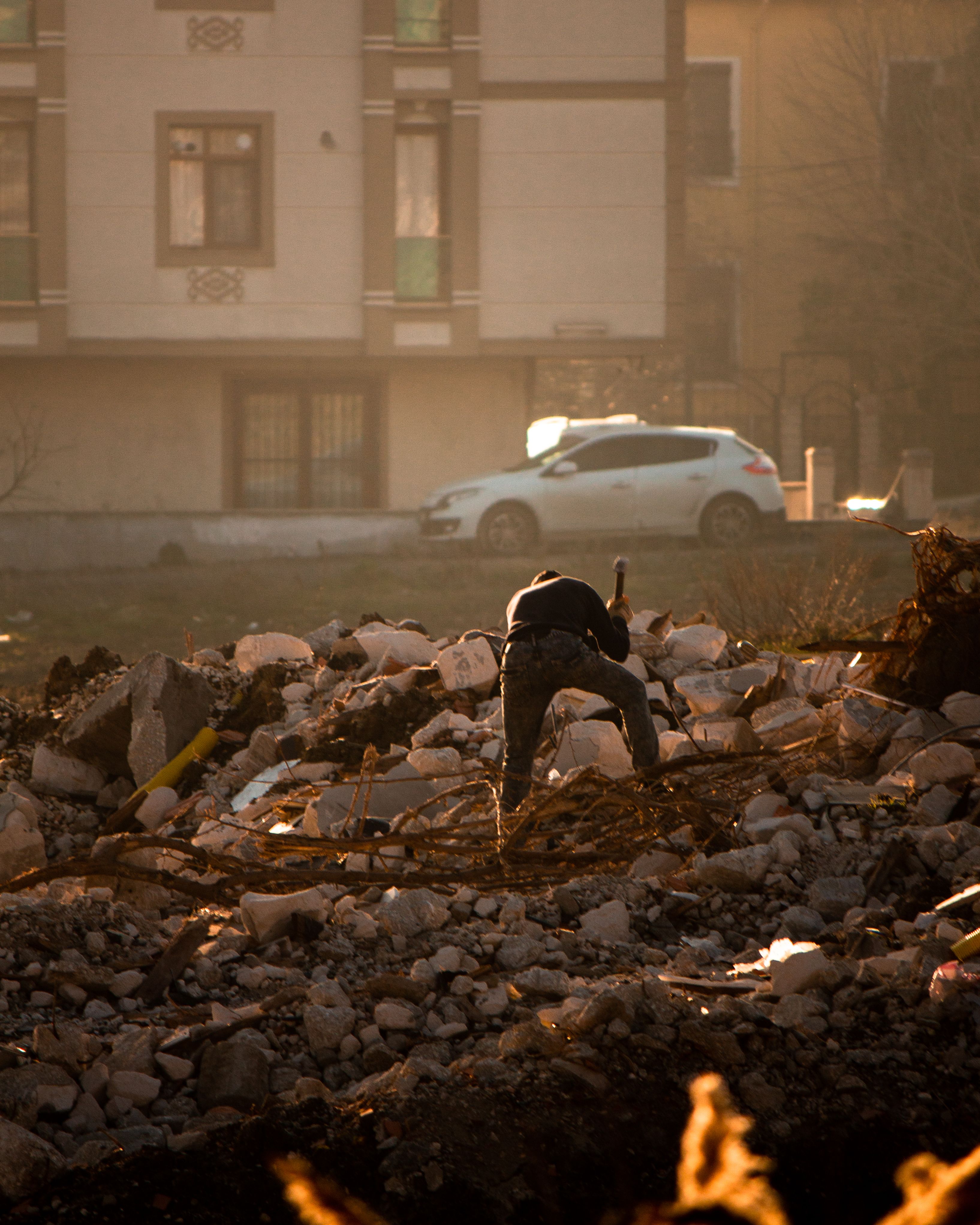 A man is walking through rubble in a city · Free Stock Photo