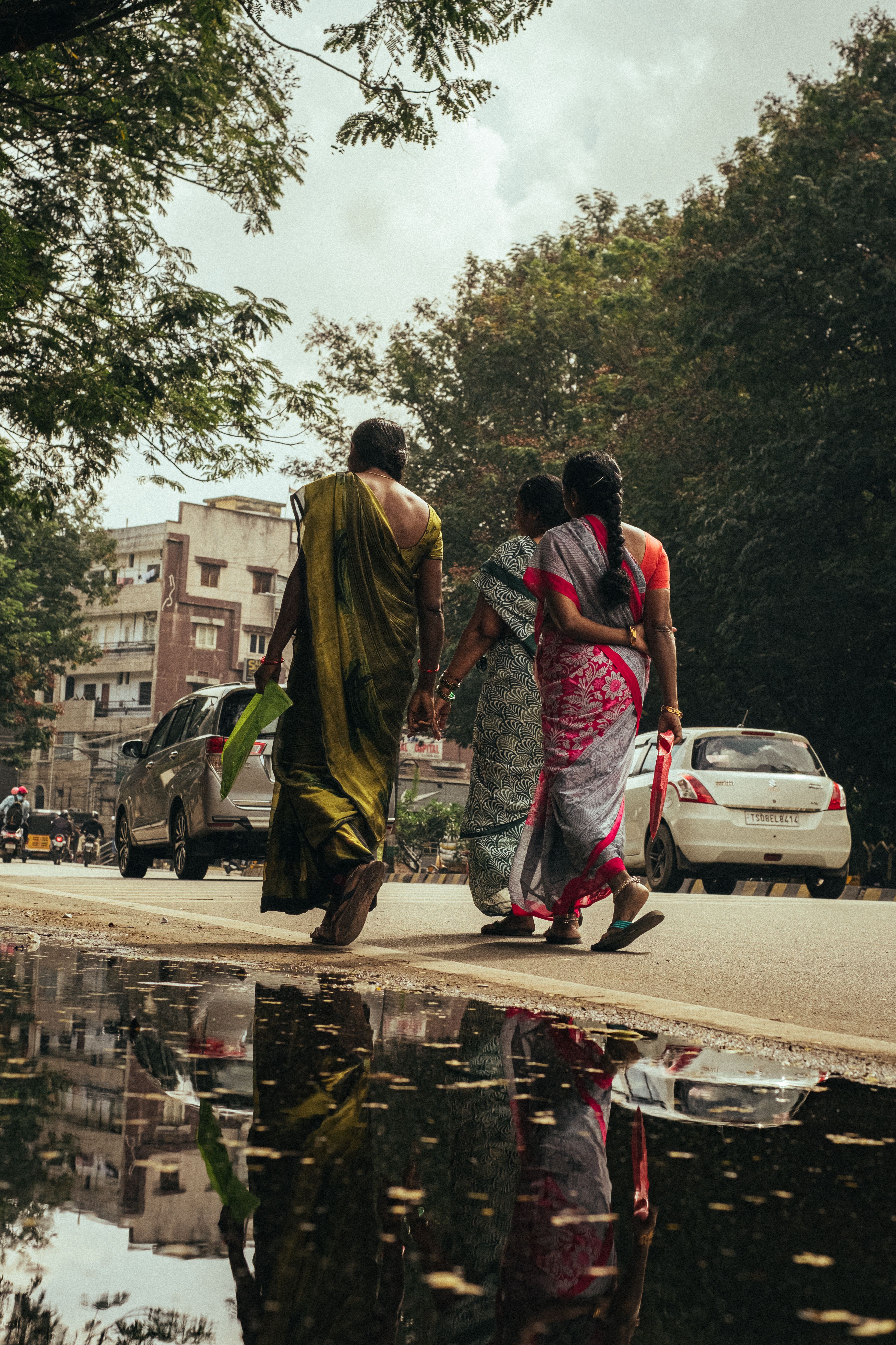 Women in Traditional Clothes Walking on the Street with Water Puddle ...