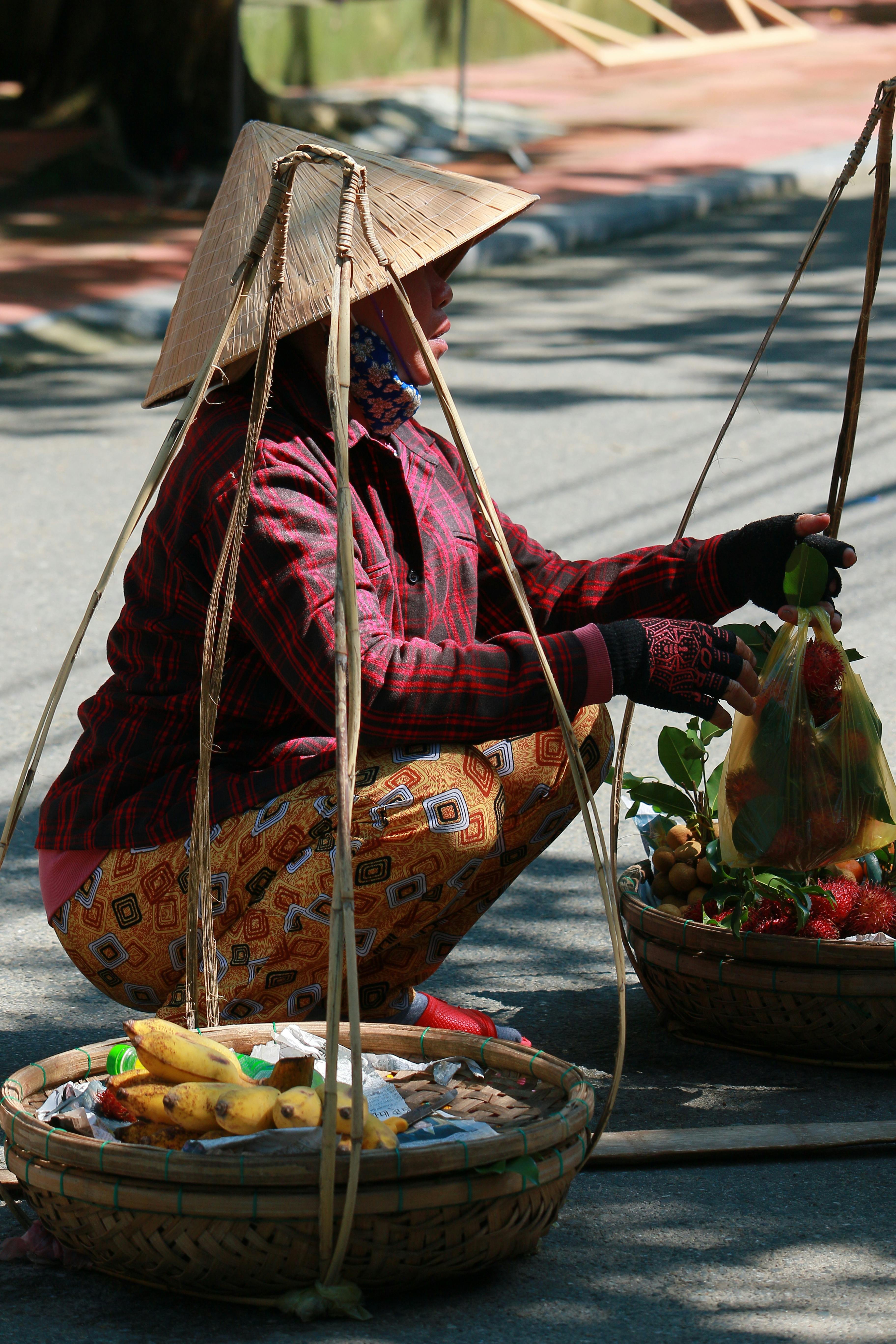 A Street Vendor Wearing a Conical Hat · Free Stock Photo