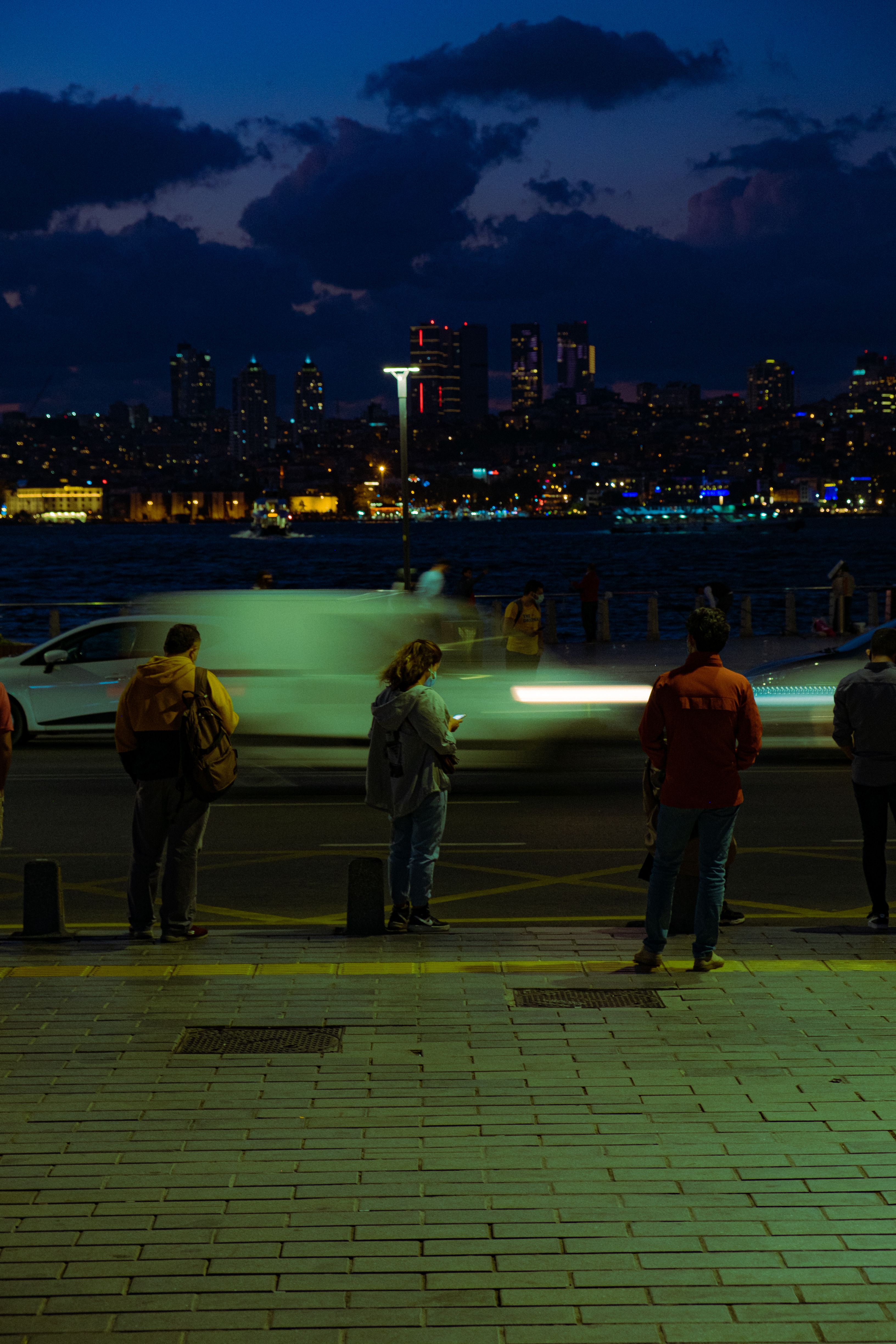People Standing on the Roadside Near Moving Cars · Free Stock Photo