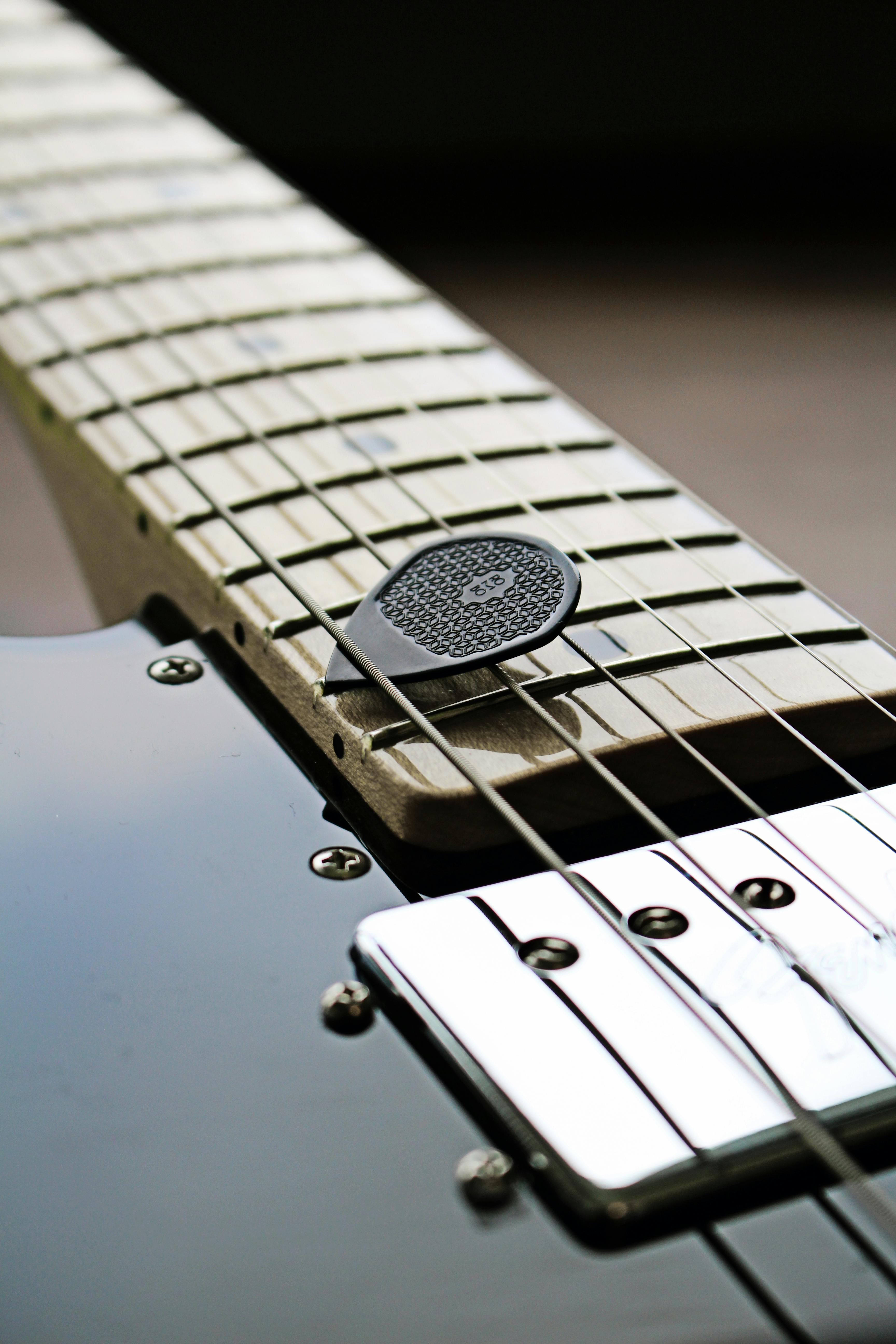 Guitar Pick laying on Fret Board and Guitar Gear · Free Stock Photo