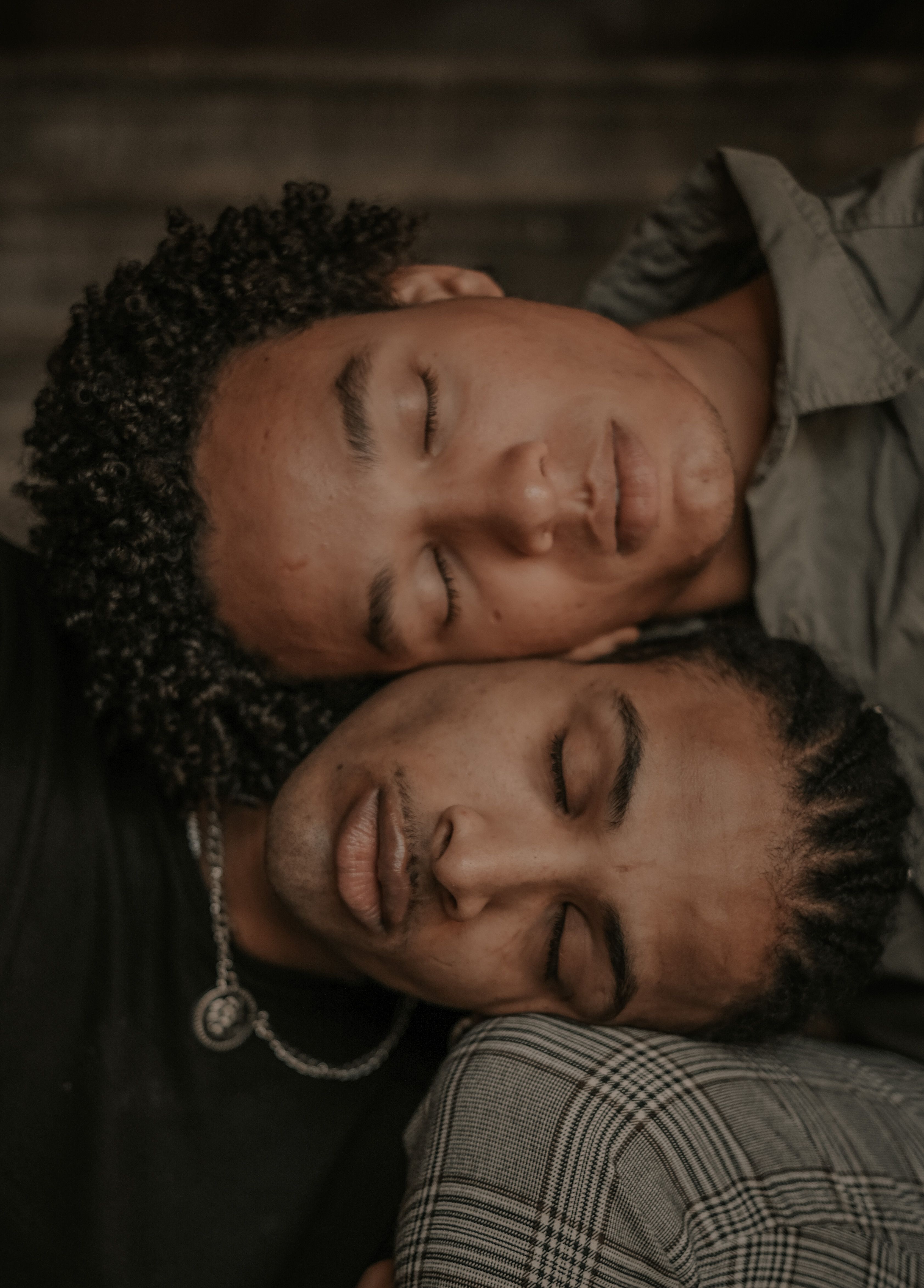 Two Men Sitting with their Heads Together · Free Stock Photo