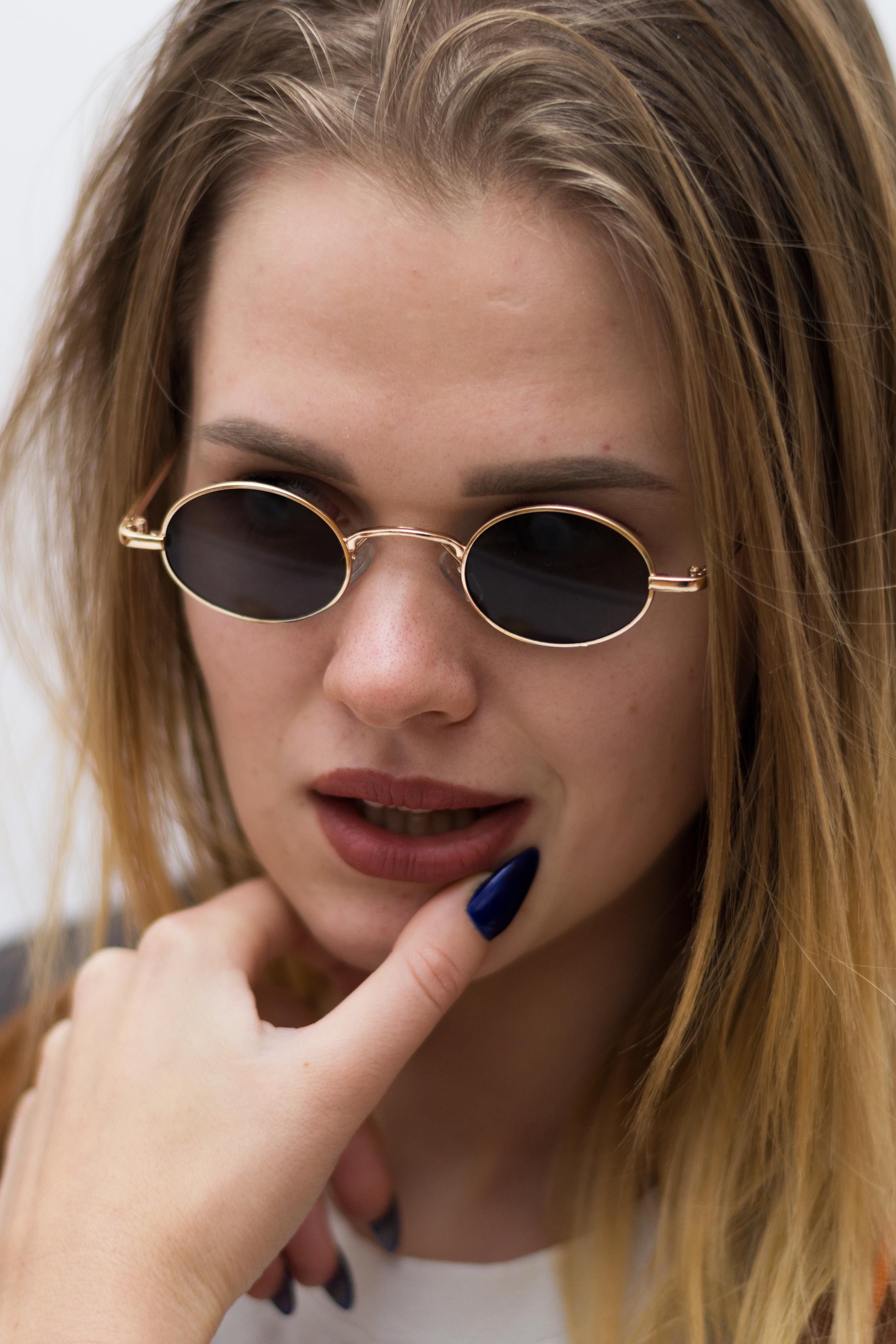 A Portrait of a Woman Wearing Round Sunglasses · Free Stock Photo