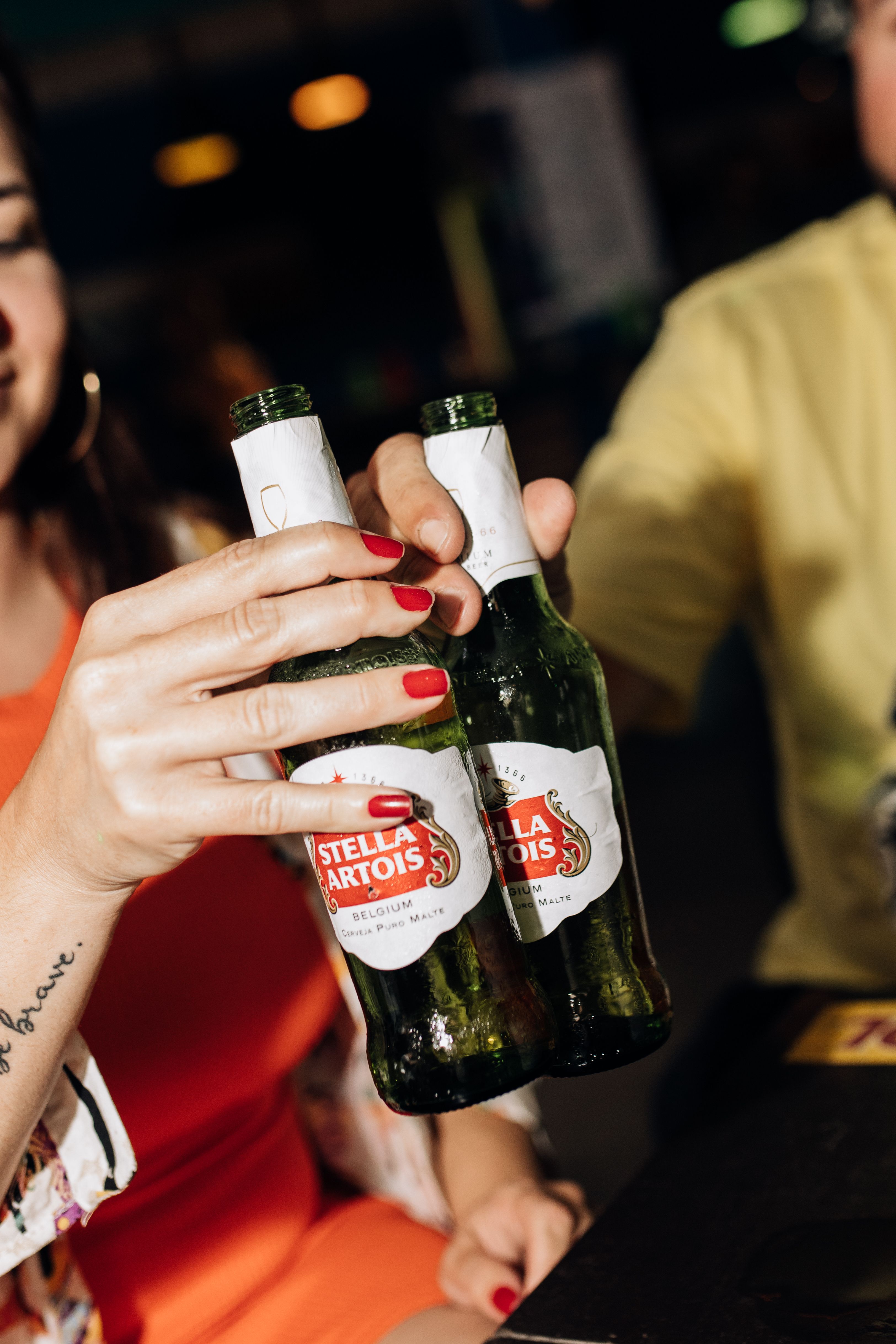 People Clinking their Beer Bottles at a Party · Free Stock Photo
