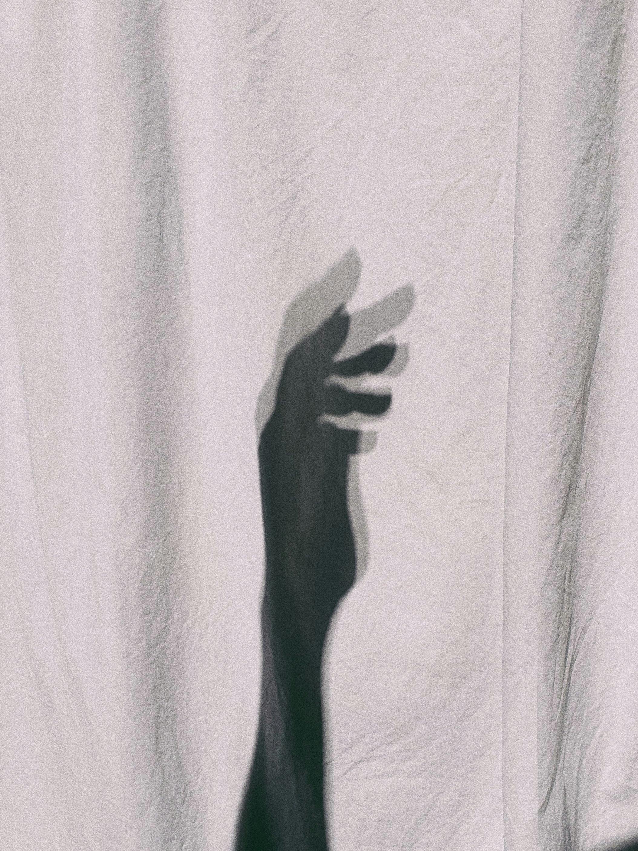 Hand of a Person Behind a Fabric · Free Stock Photo