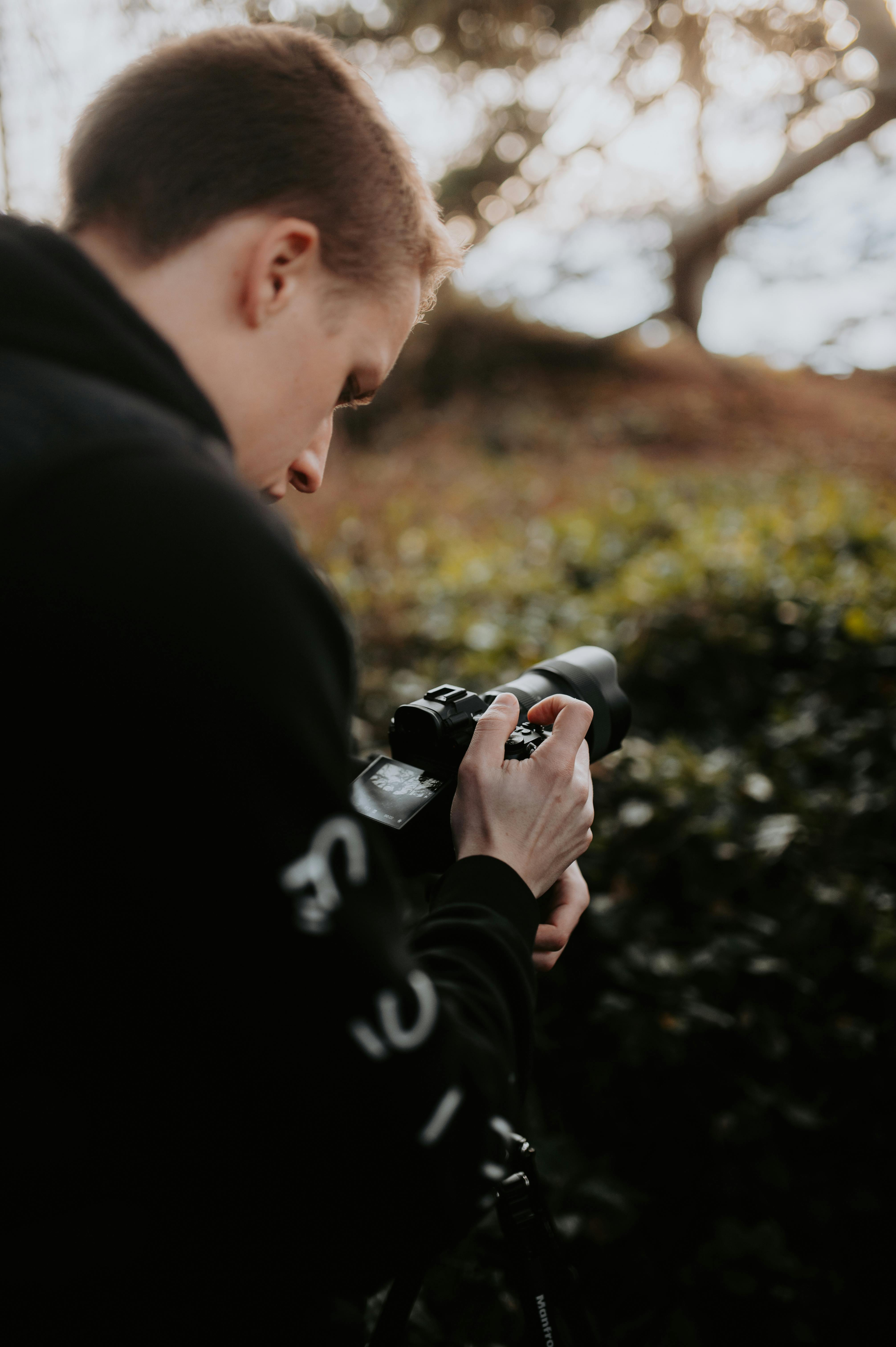 Photography of Man Holding Dslr Camera · Free Stock Photo