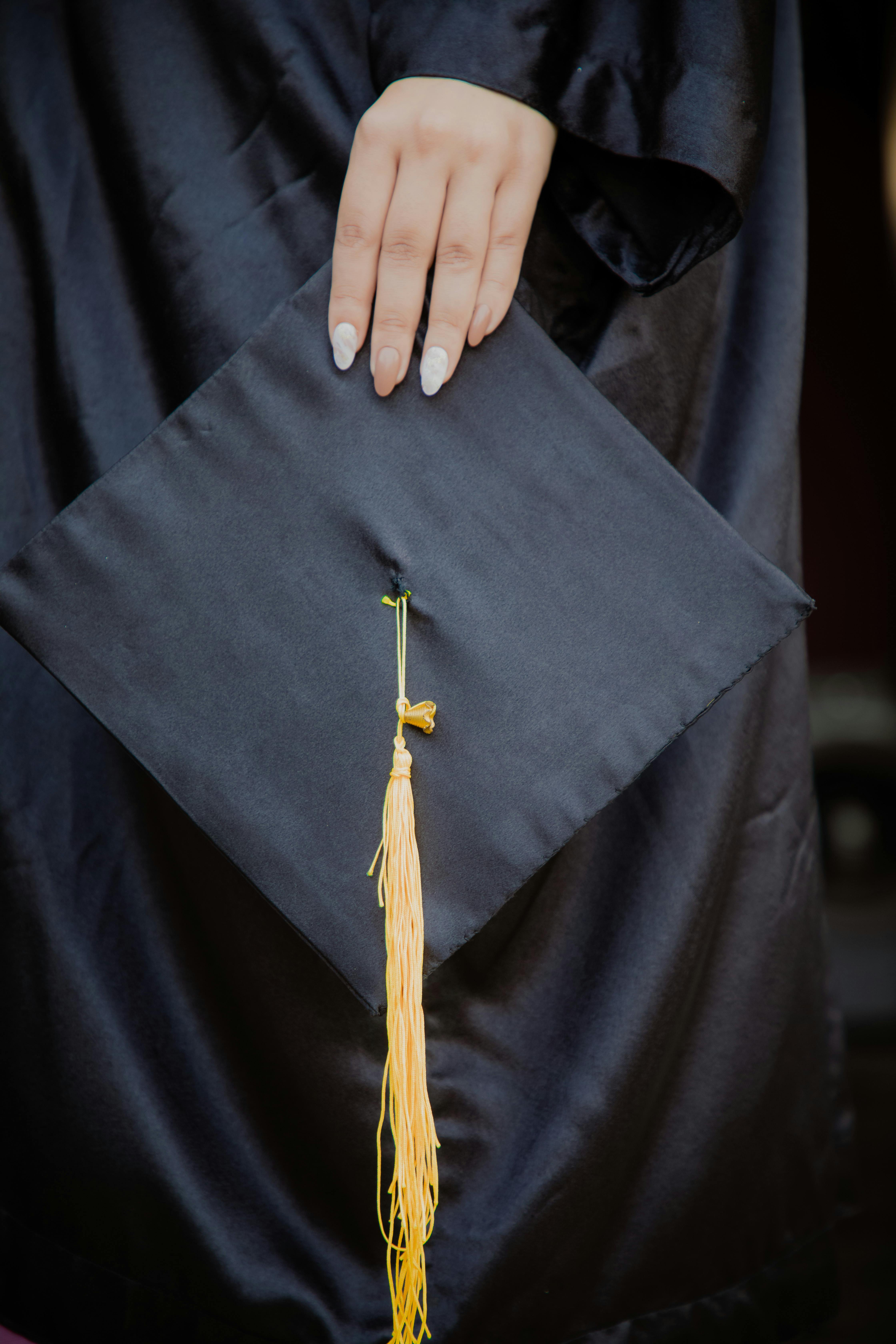 Close-Up Shot of a Person Holding Square Academic Cap and Diploma ...