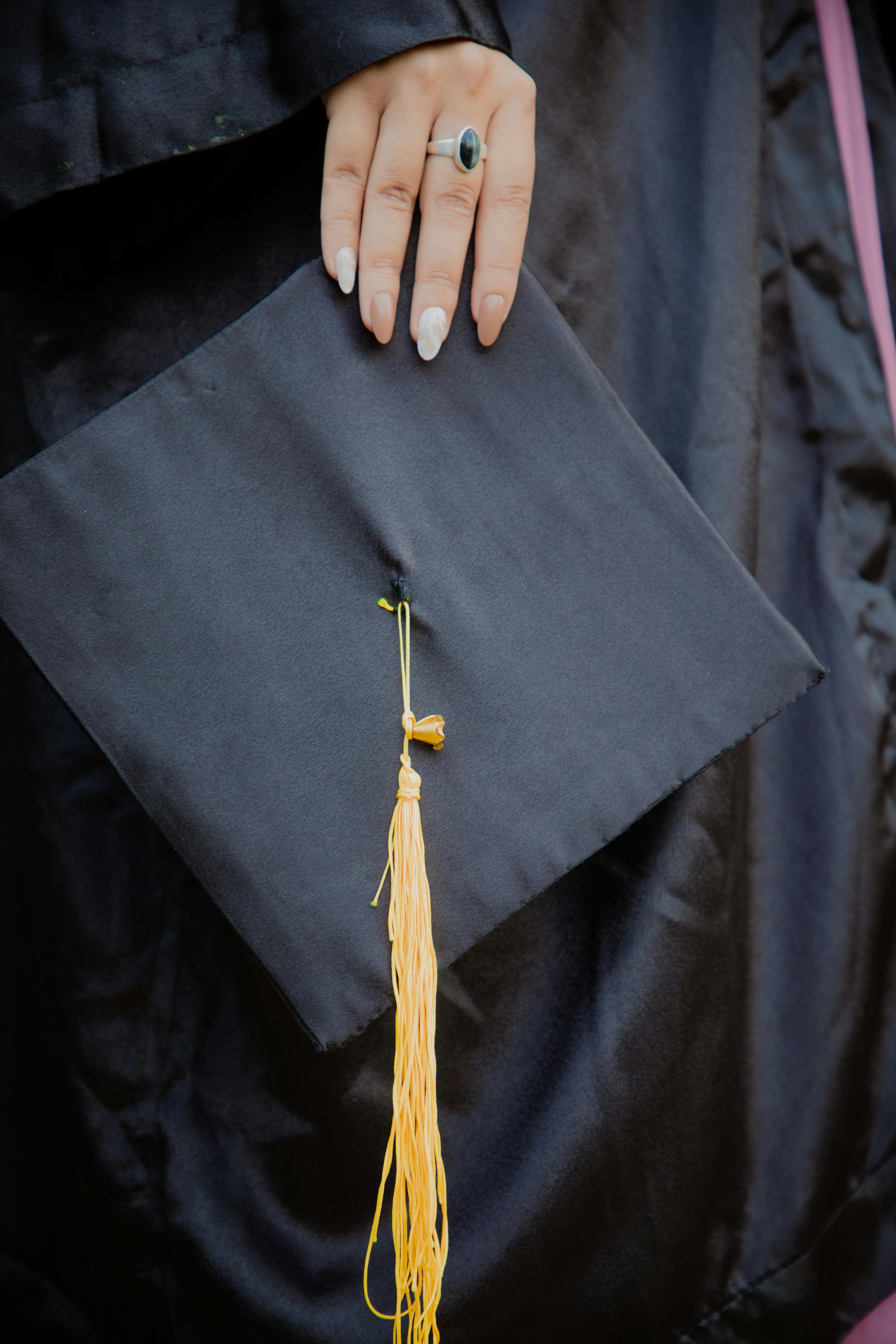 Close-Up Shot of a Person Holding Square Academic Cap and Diploma ...