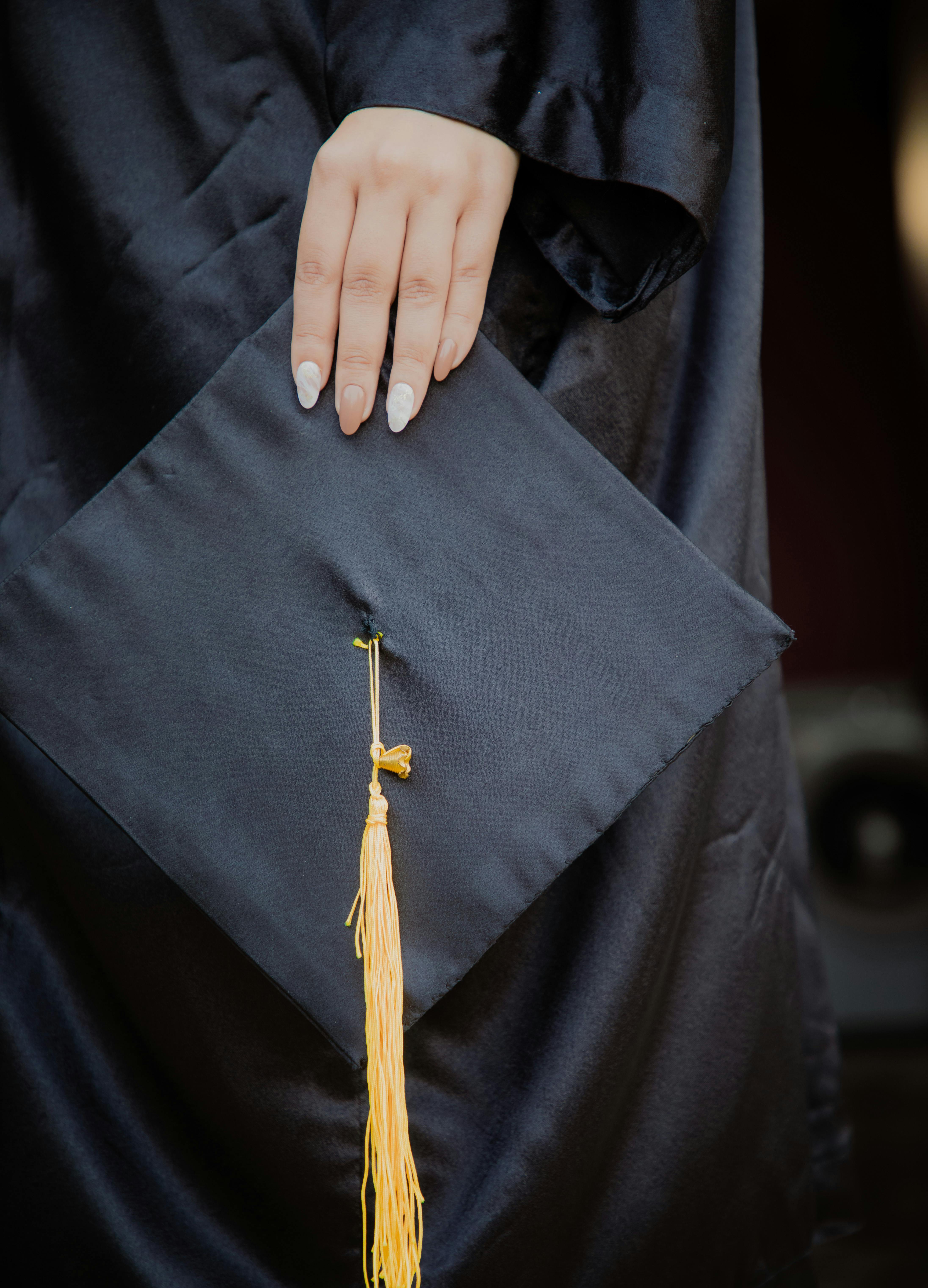Hand Holding a Graduation Cap · Free Stock Photo
