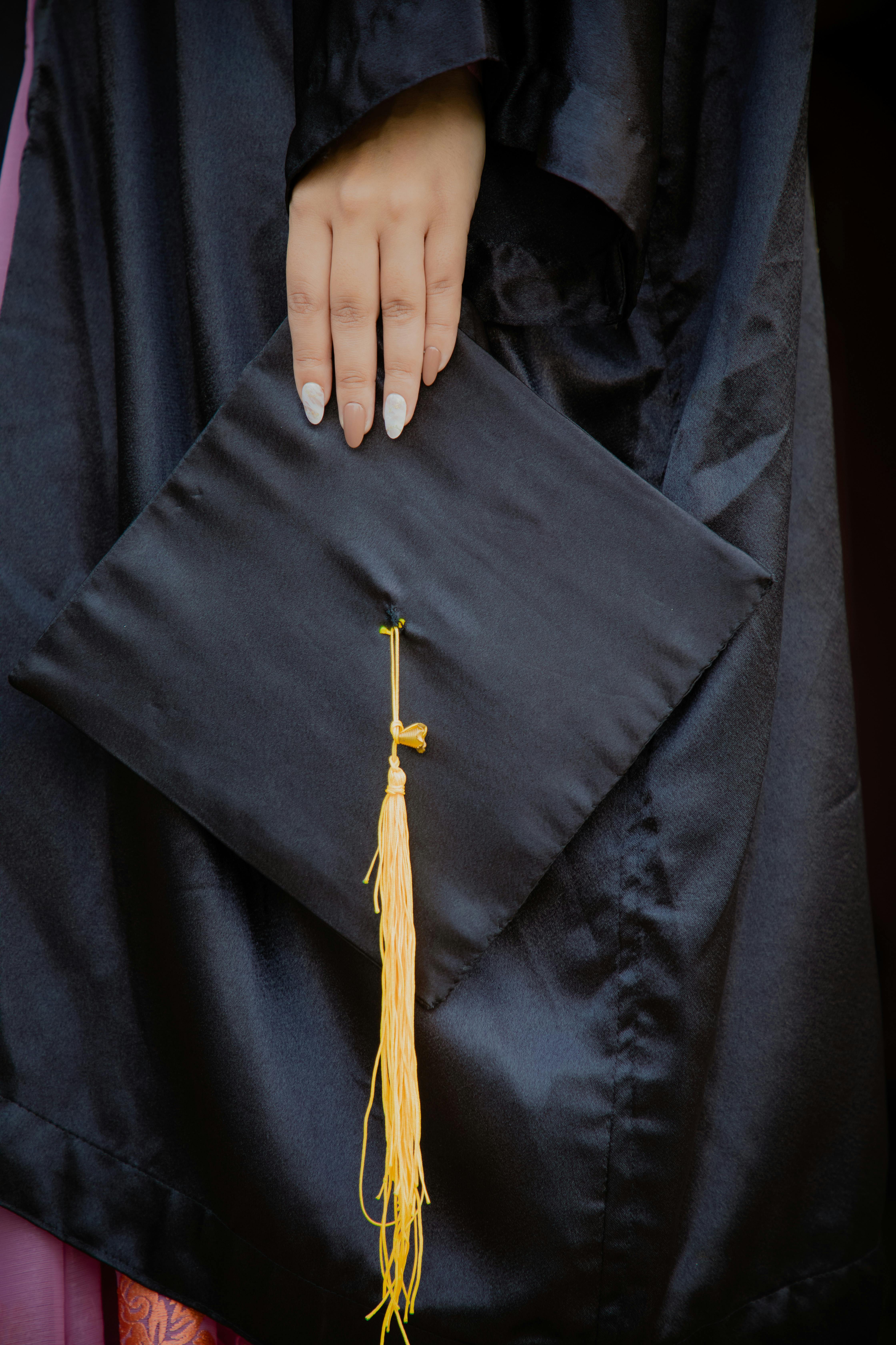 A Person Holding Black Graduation Cap · Free Stock Photo